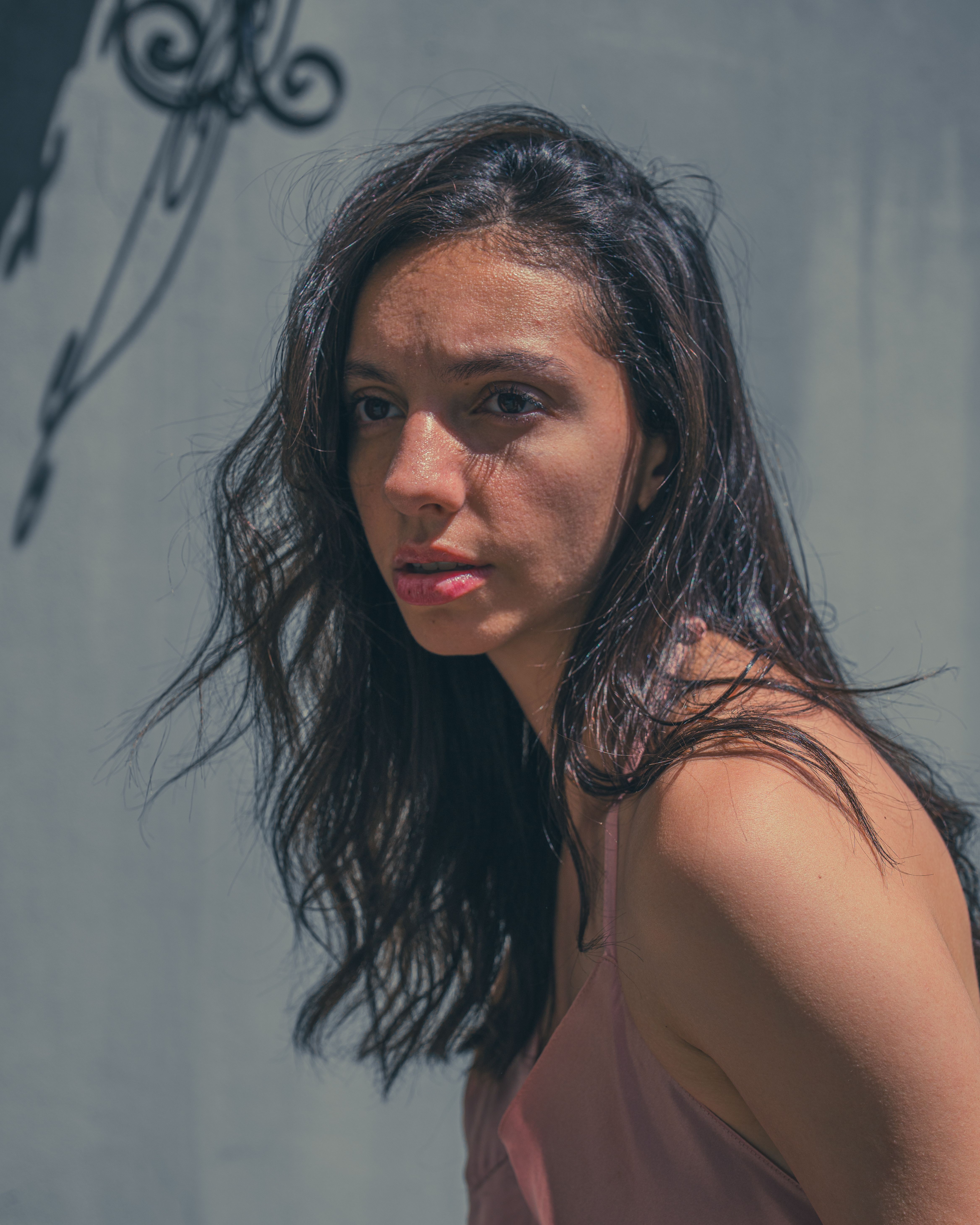 Thoughtful Woman in Sunlit Portrait Outdoors · Free Stock Photo