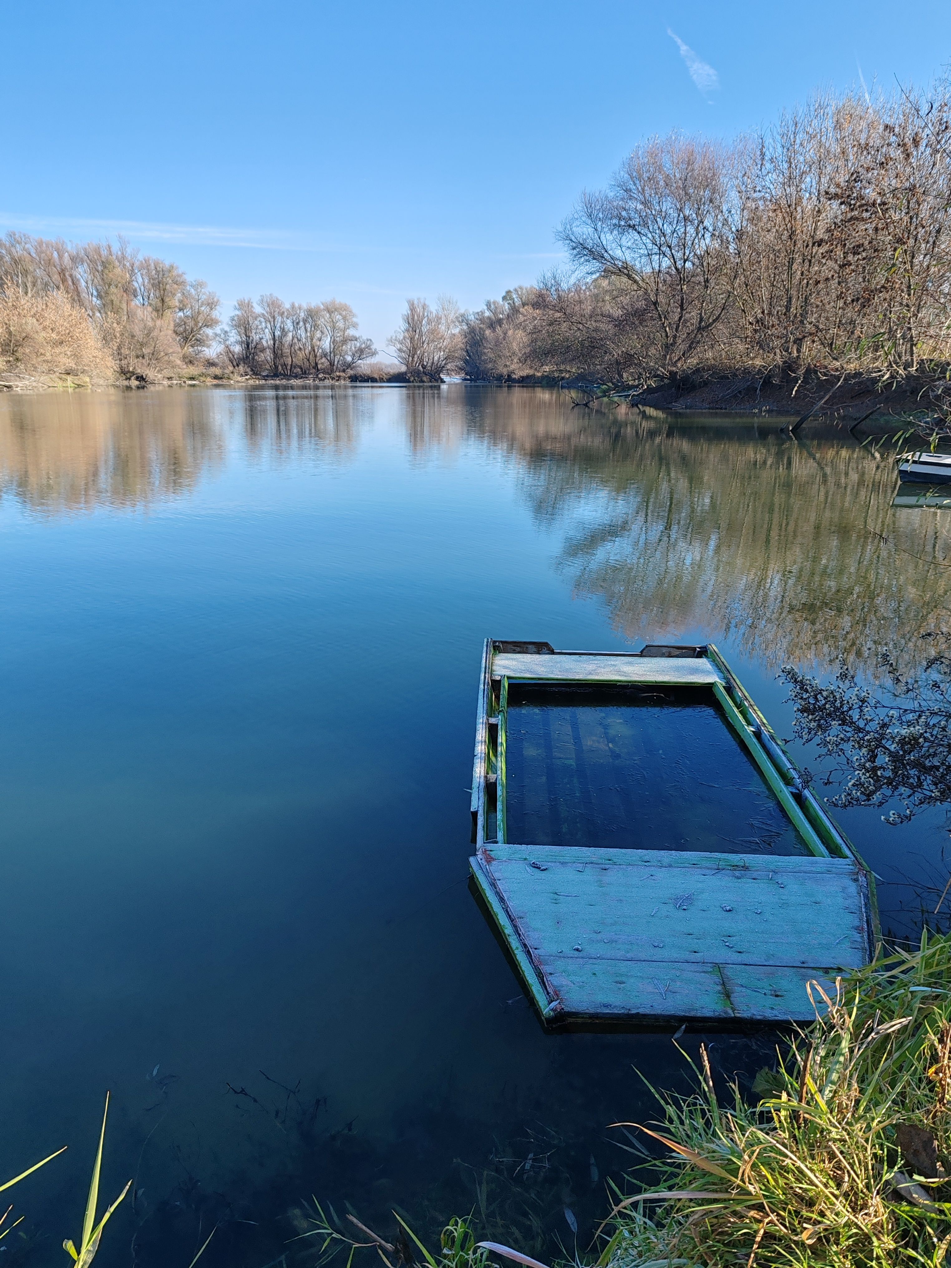 Serene Riverside Scene with Wooden Boat · Free Stock Photo