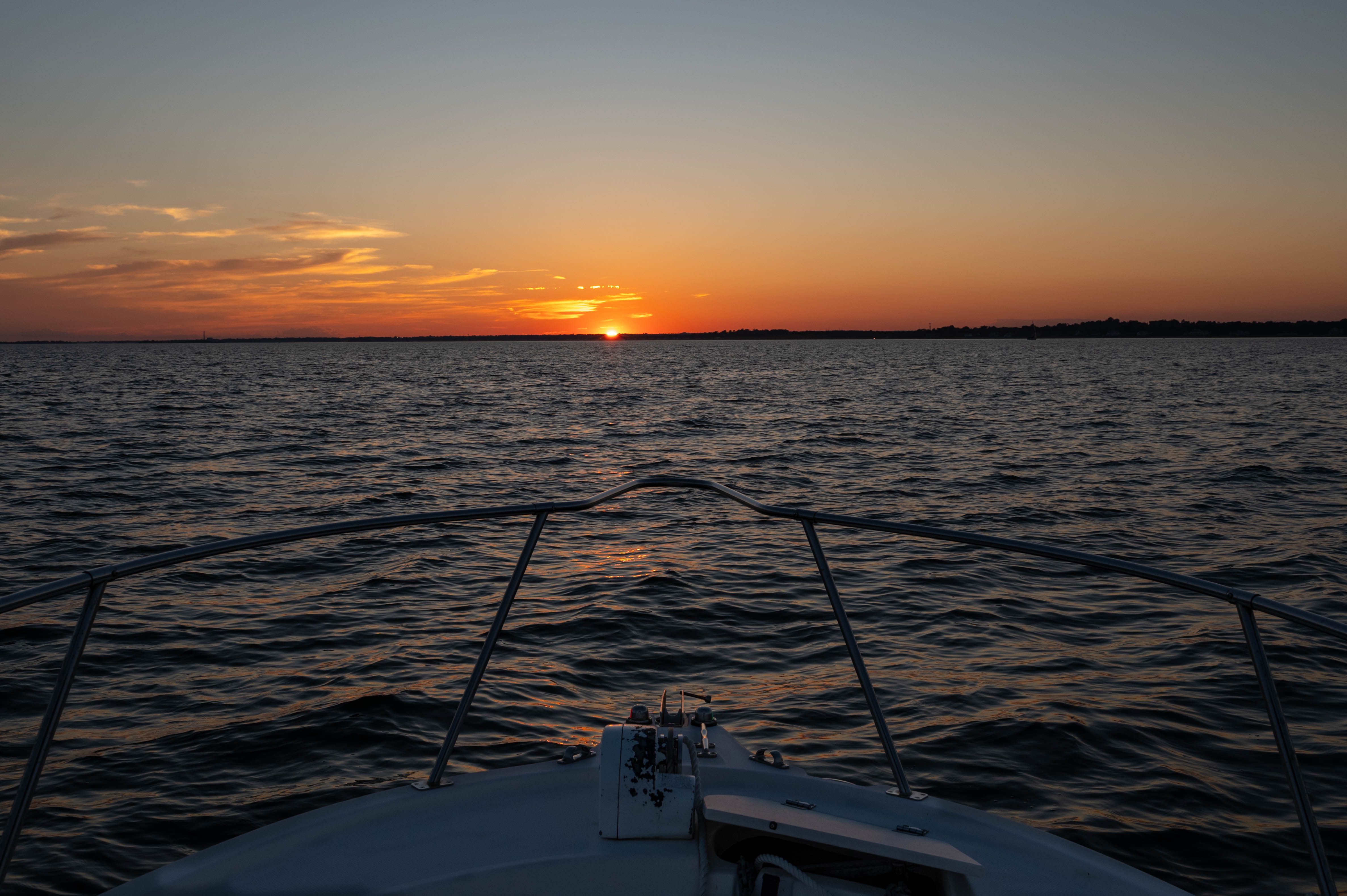 Boat on Open Sea at Sunset with Vibrant Sky · Free Stock Photo