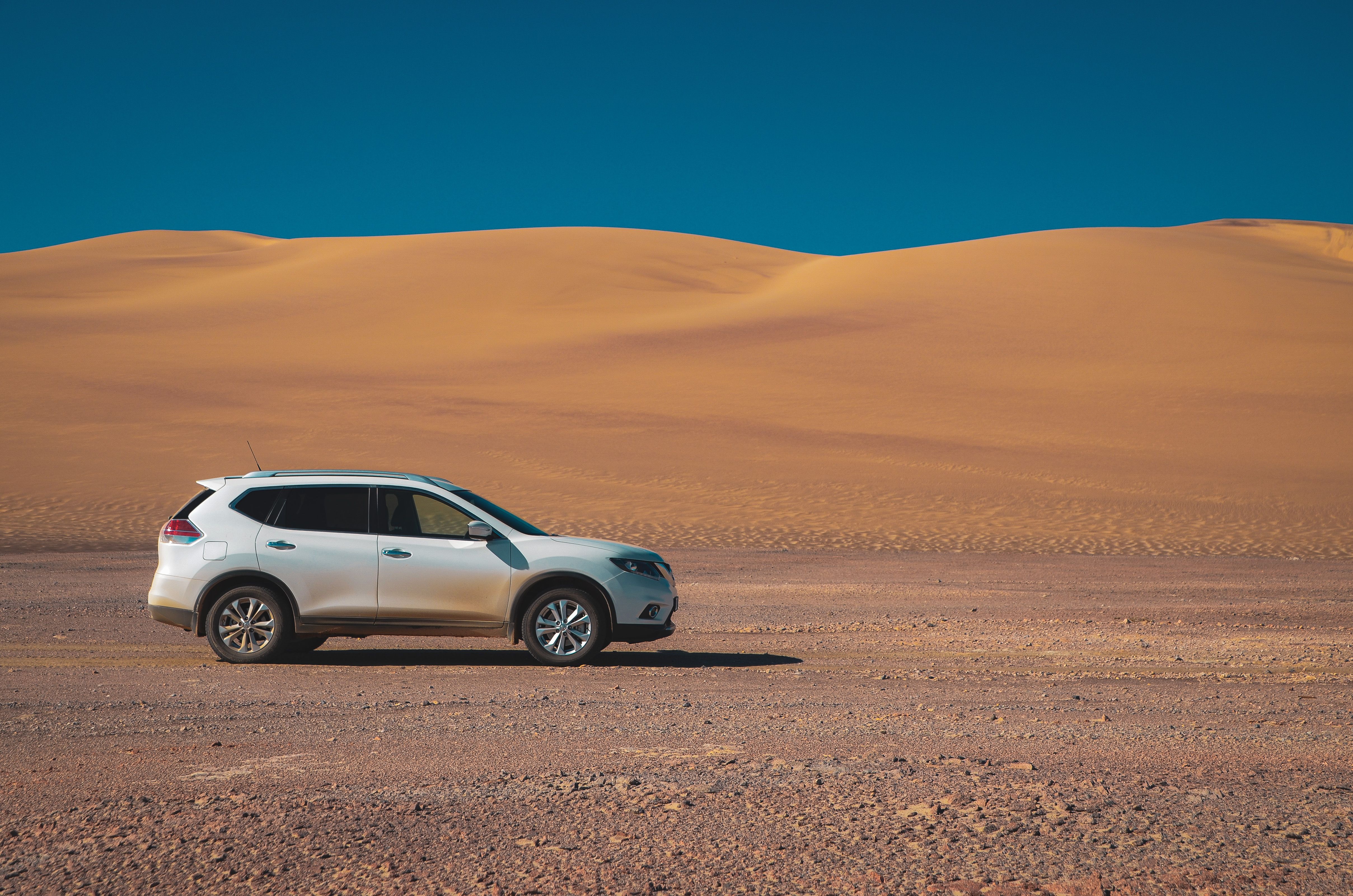 White SUV on Desert Road Under Blue Sky · Free Stock Photo
