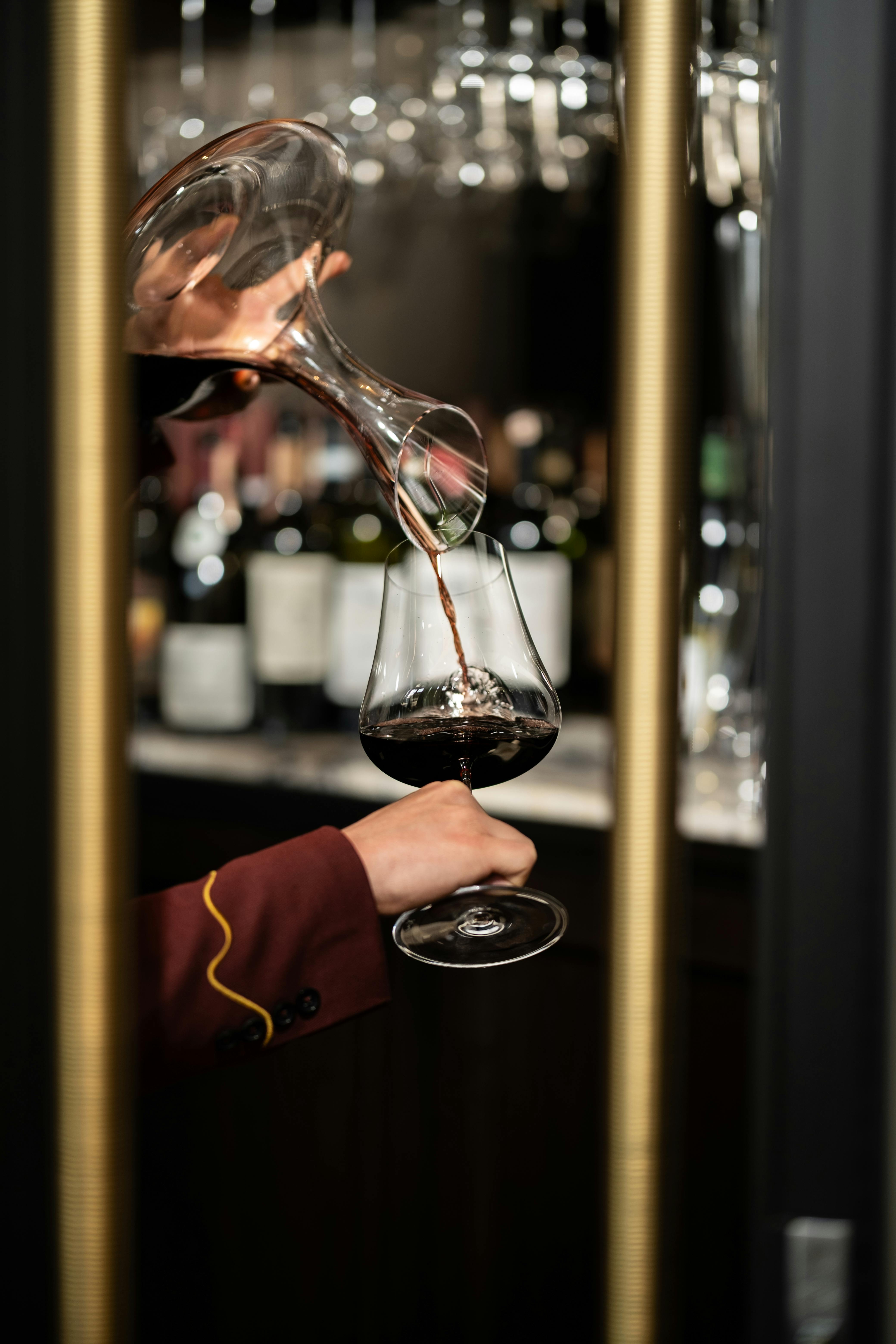 Sommelier Pouring Red Wine into Glass in Elegant Setting · Free Stock Photo