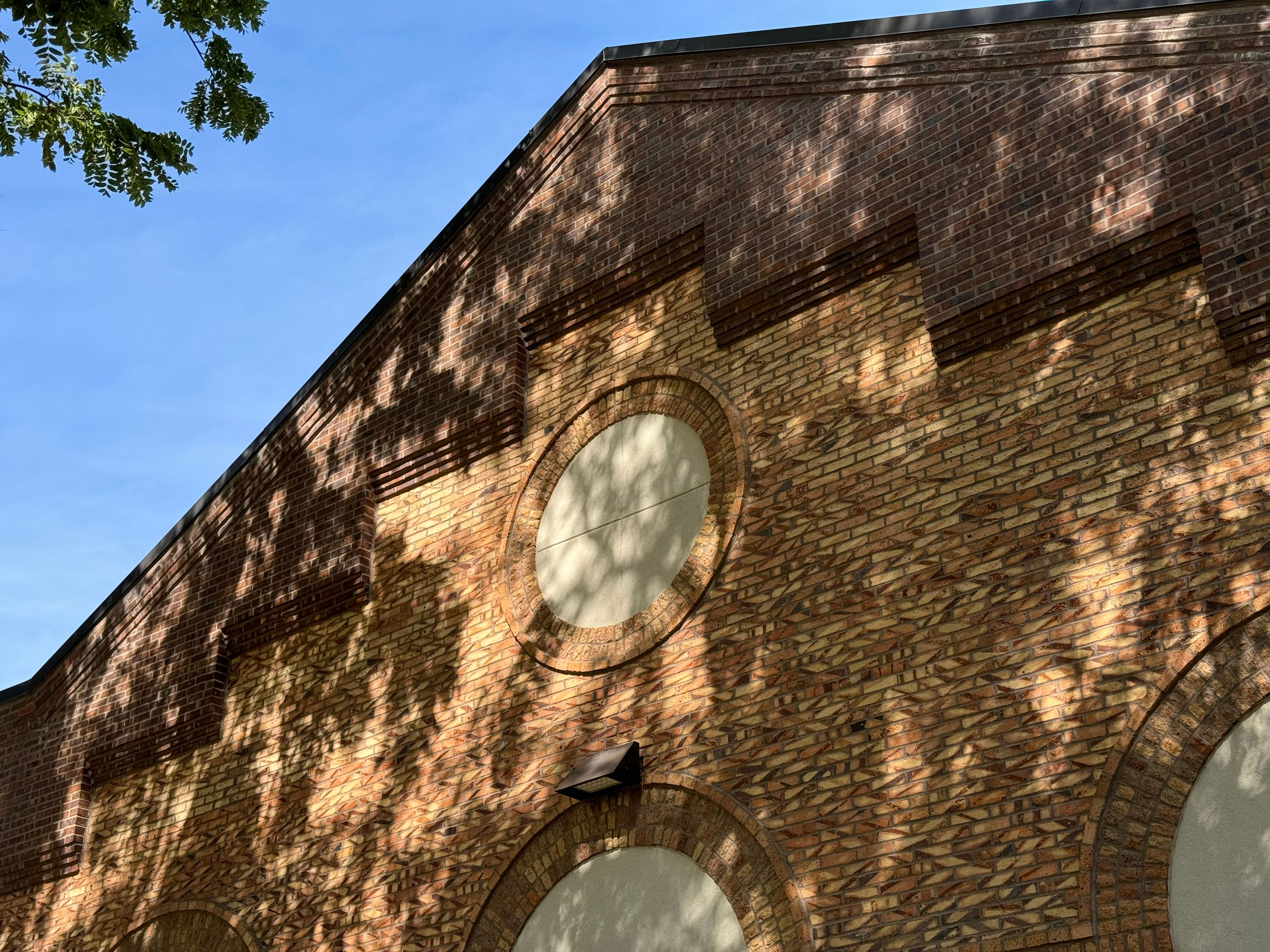 Sunlit Brick Building with Circular Windows · Free Stock Photo