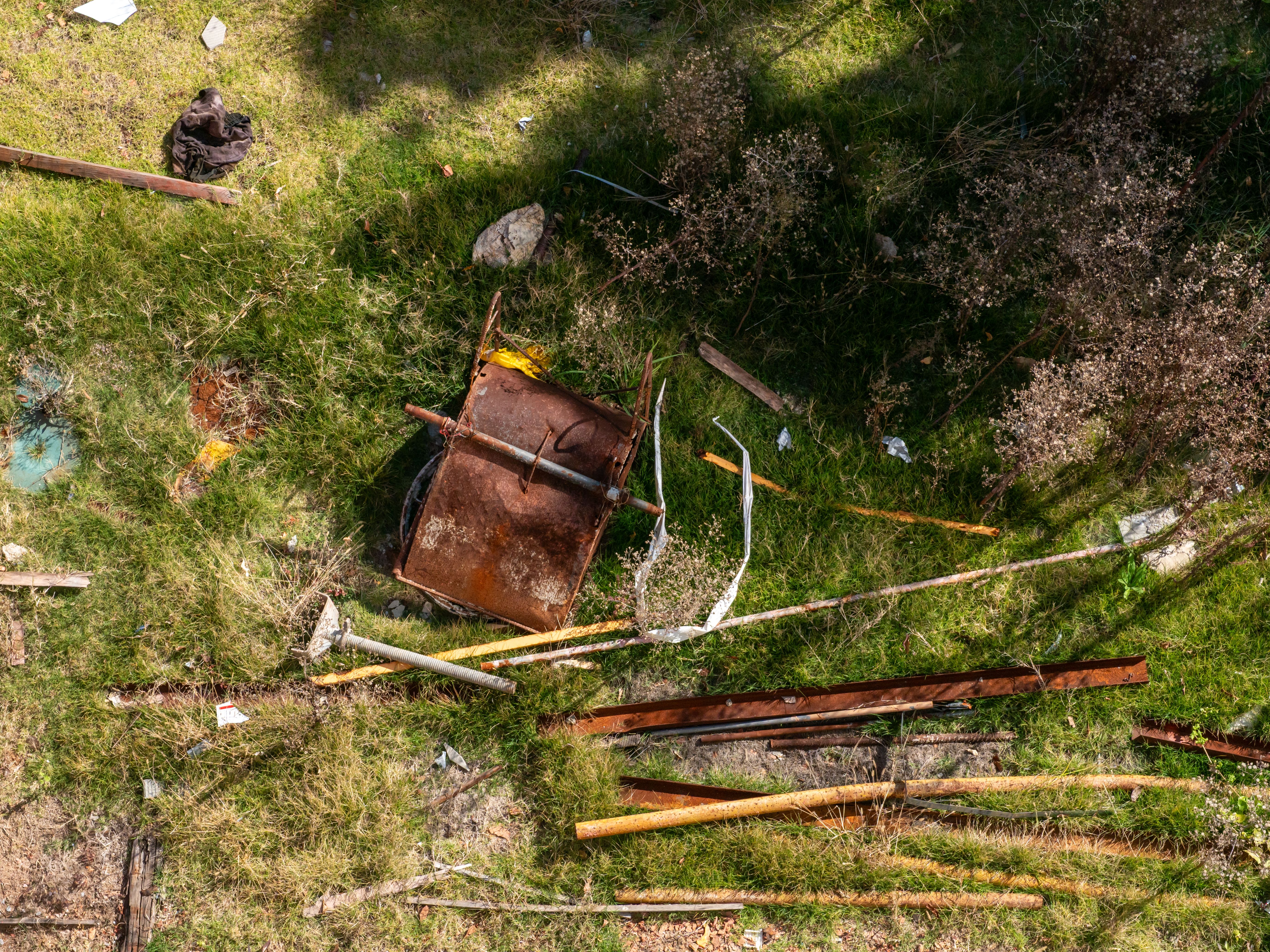 Aerial View of Abandoned Rusty Scrap Metal in Grassland · Free Stock Photo
