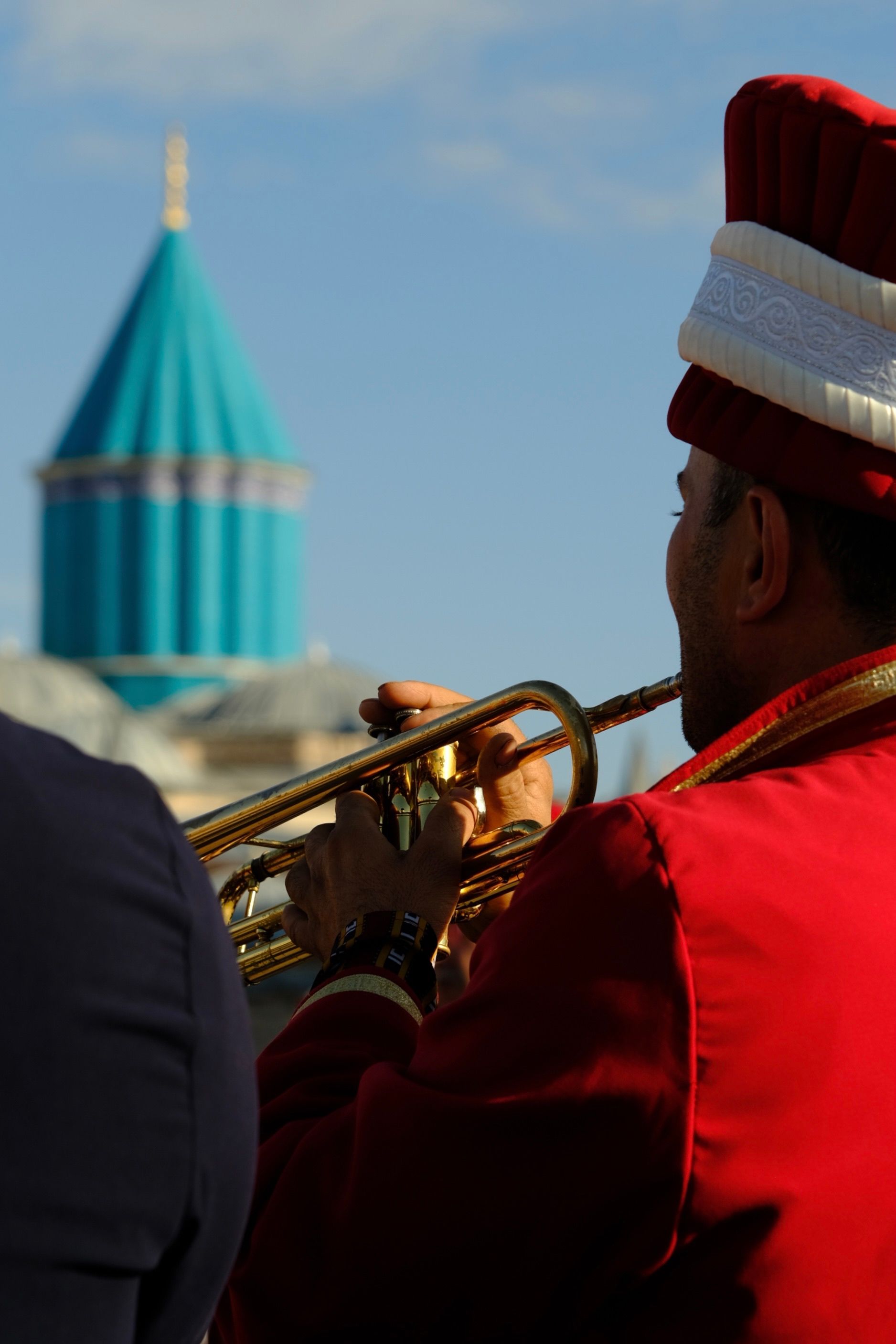 Musician in Traditional Attire Playing Trumpet Outdoors · Free Stock Photo