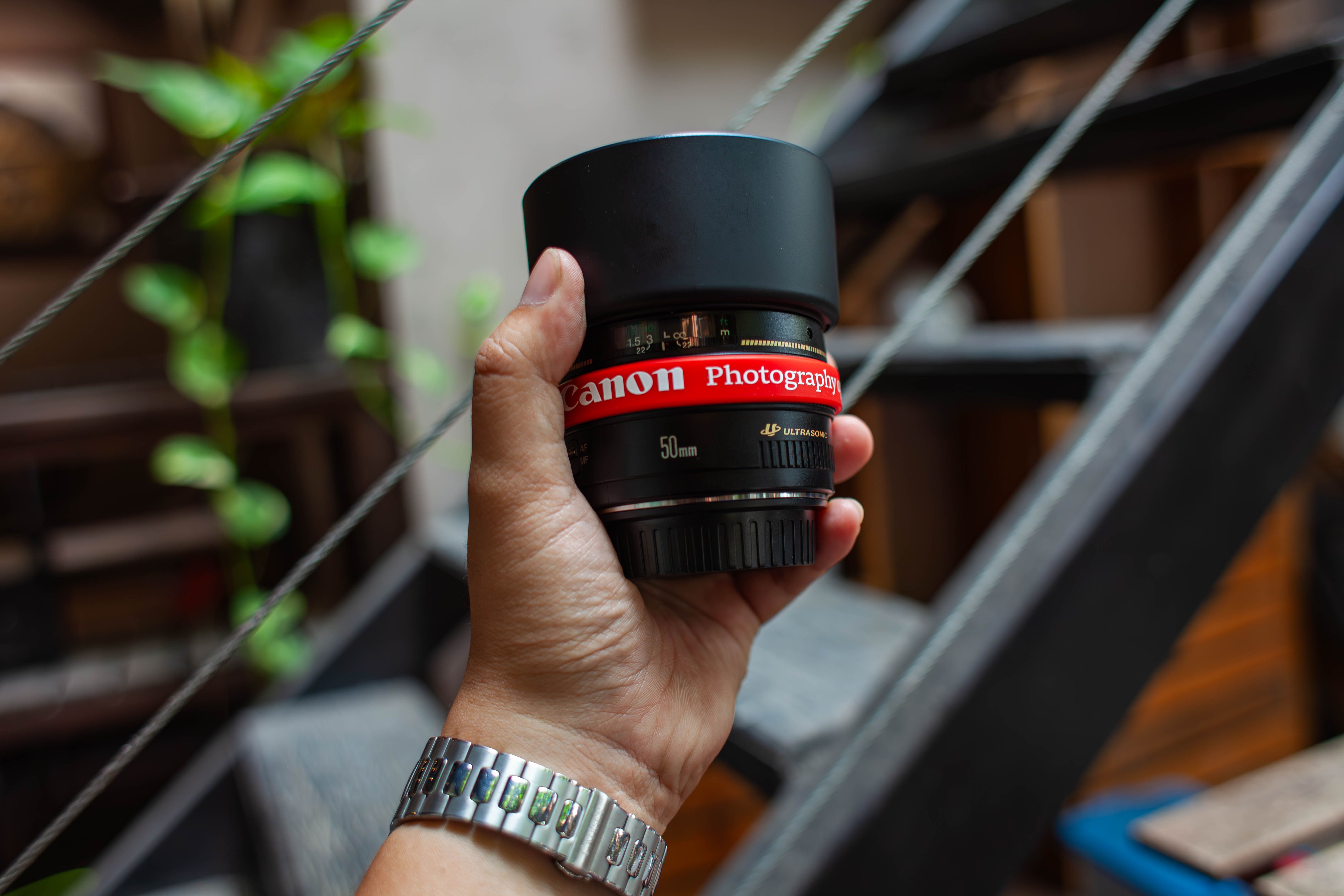Close-up of Hand Holding Camera Lens Indoors · Free Stock Photo