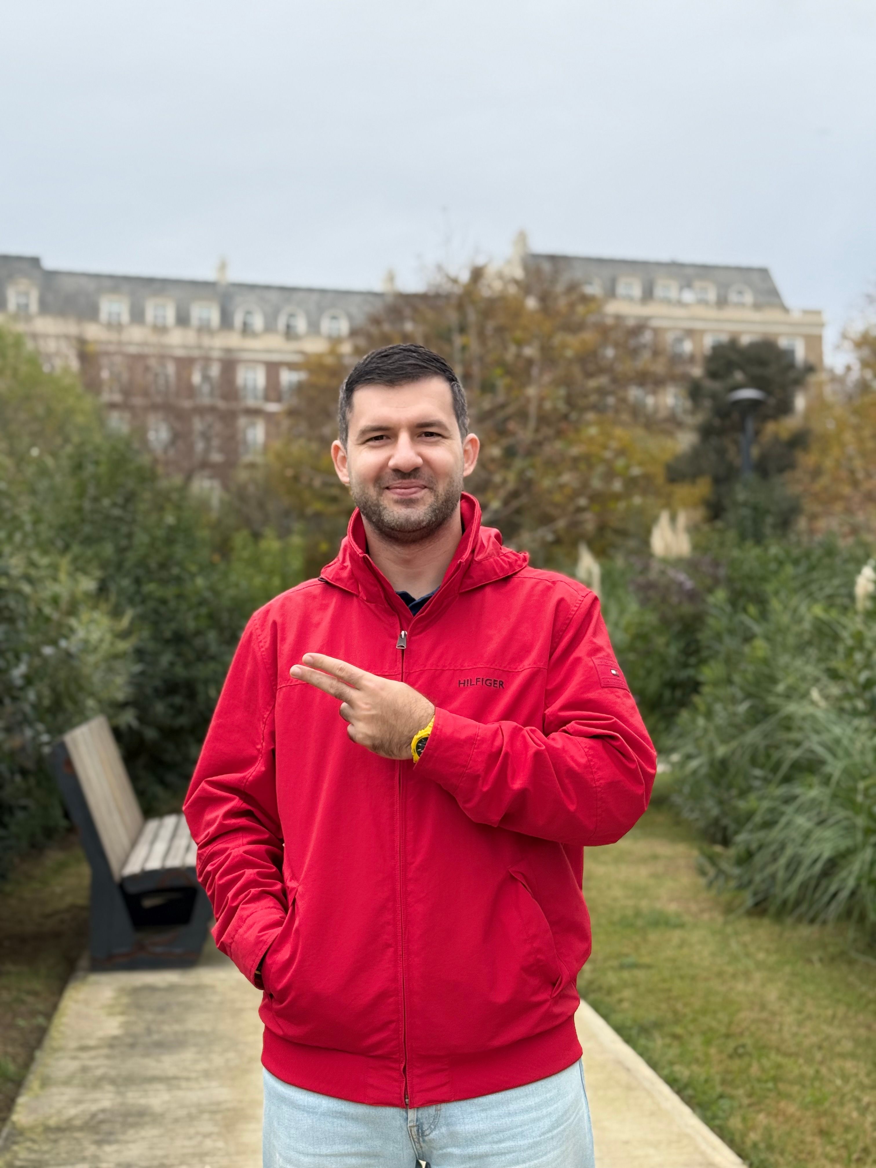 Man in Red Jacket Posing Outdoors in Baku Park · Free Stock Photo