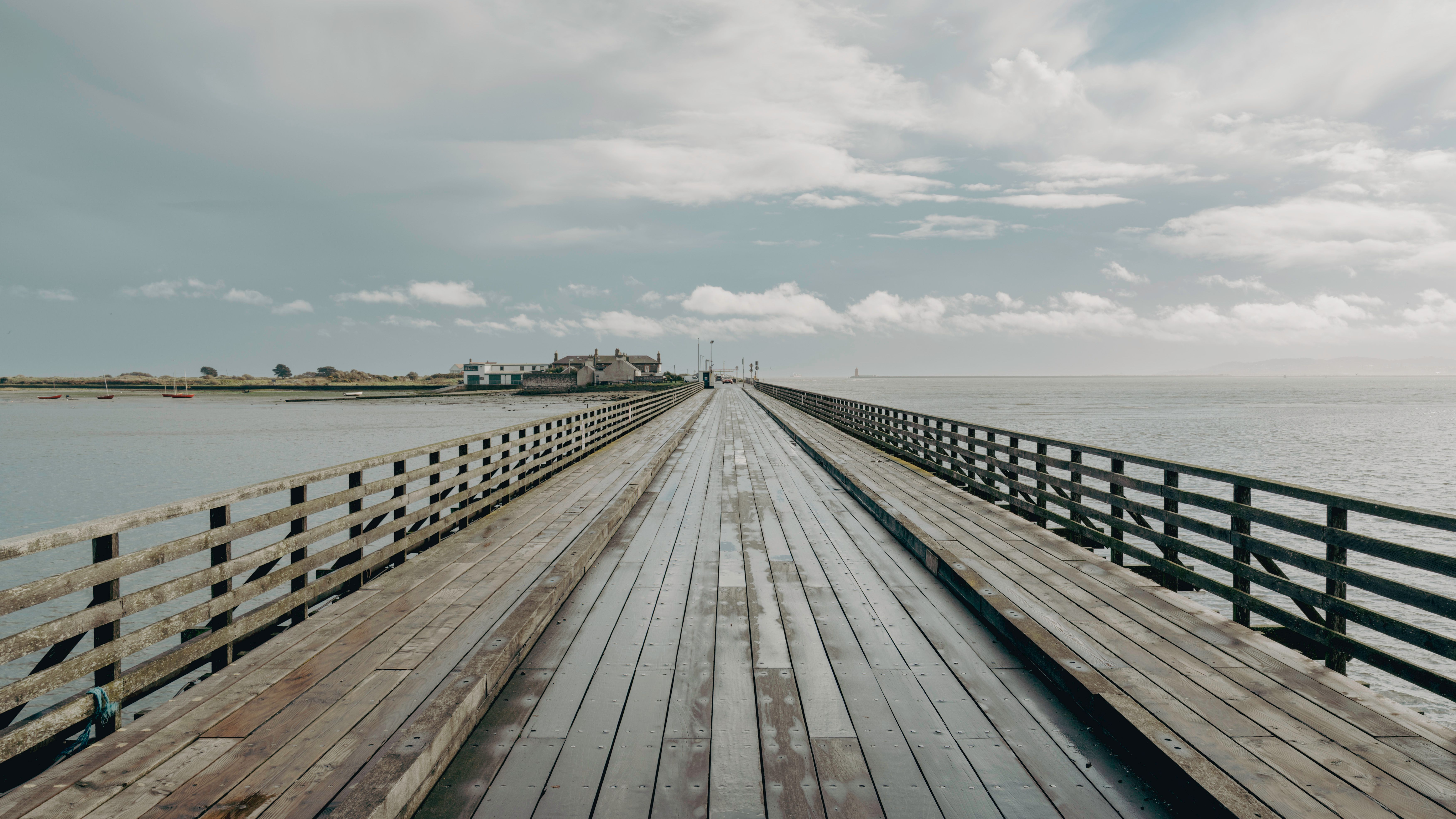 Scenic Wooden Pier Extending into Calm Irish Waters · Free Stock Photo