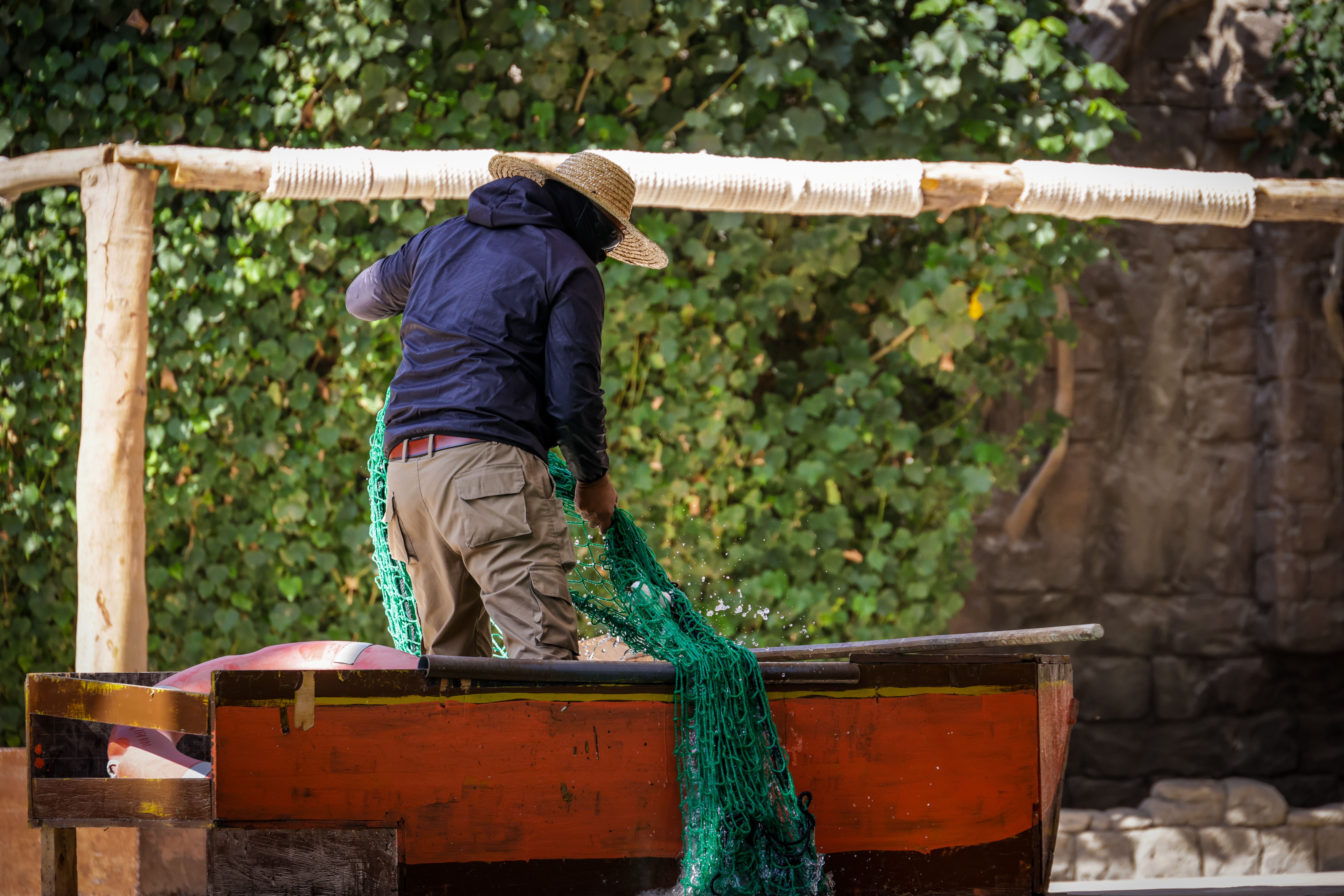 Fisherman Handling Net in Rustic Setting · Free Stock Photo