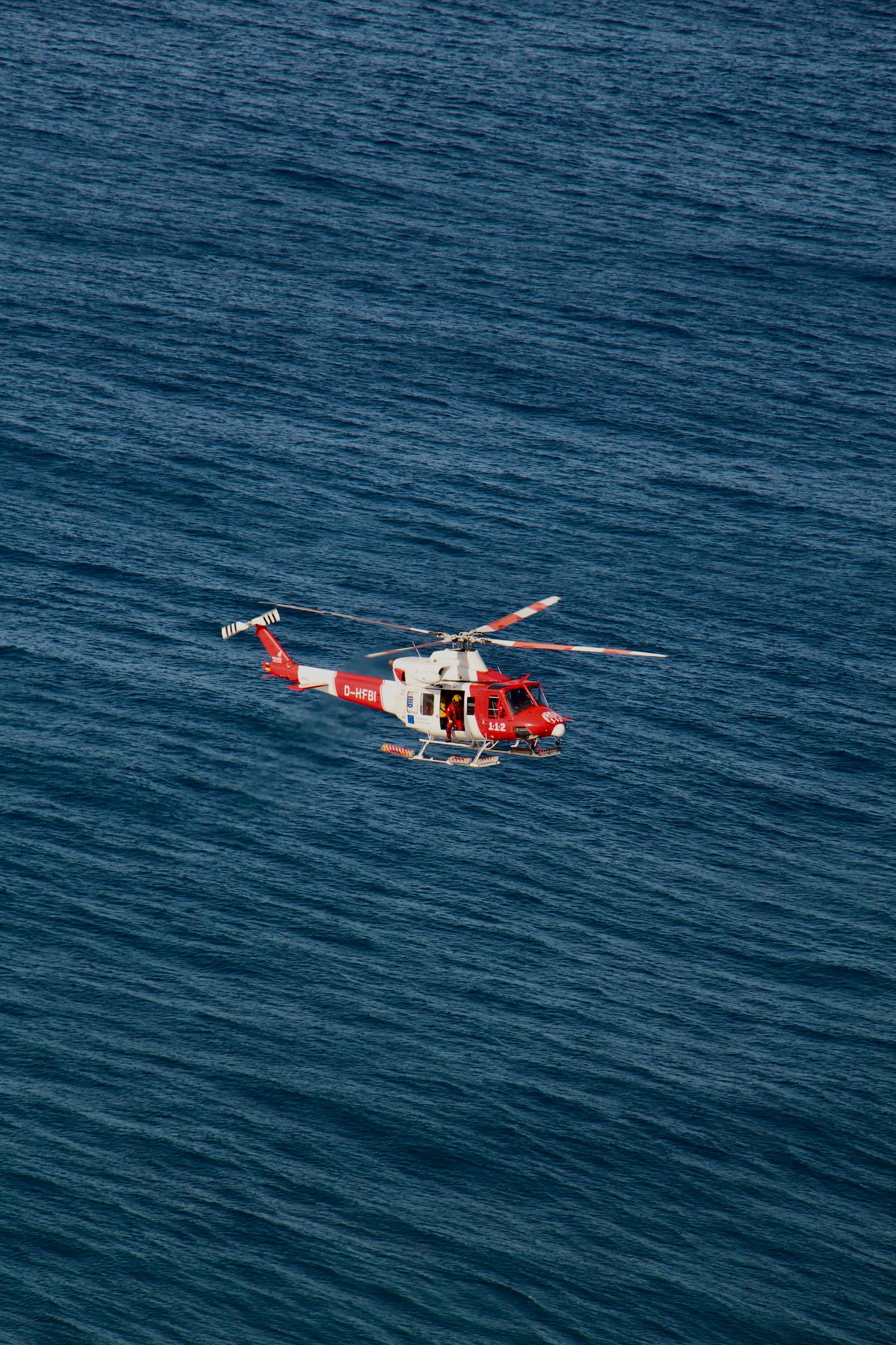 Red Rescue Helicopter Over Ocean Waters · Free Stock Photo