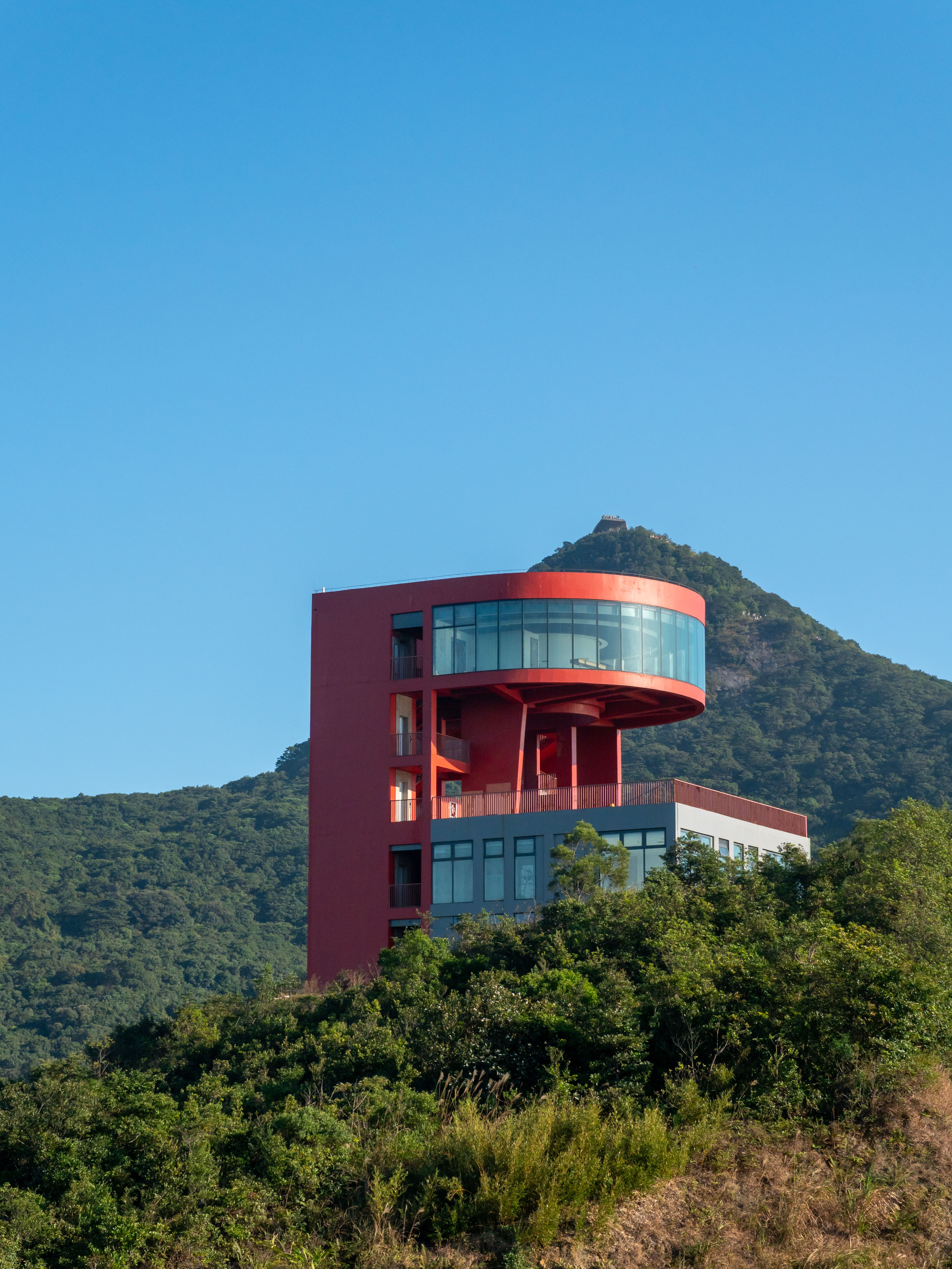 Modern Red Building against Mountain Backdrop · Free Stock Photo