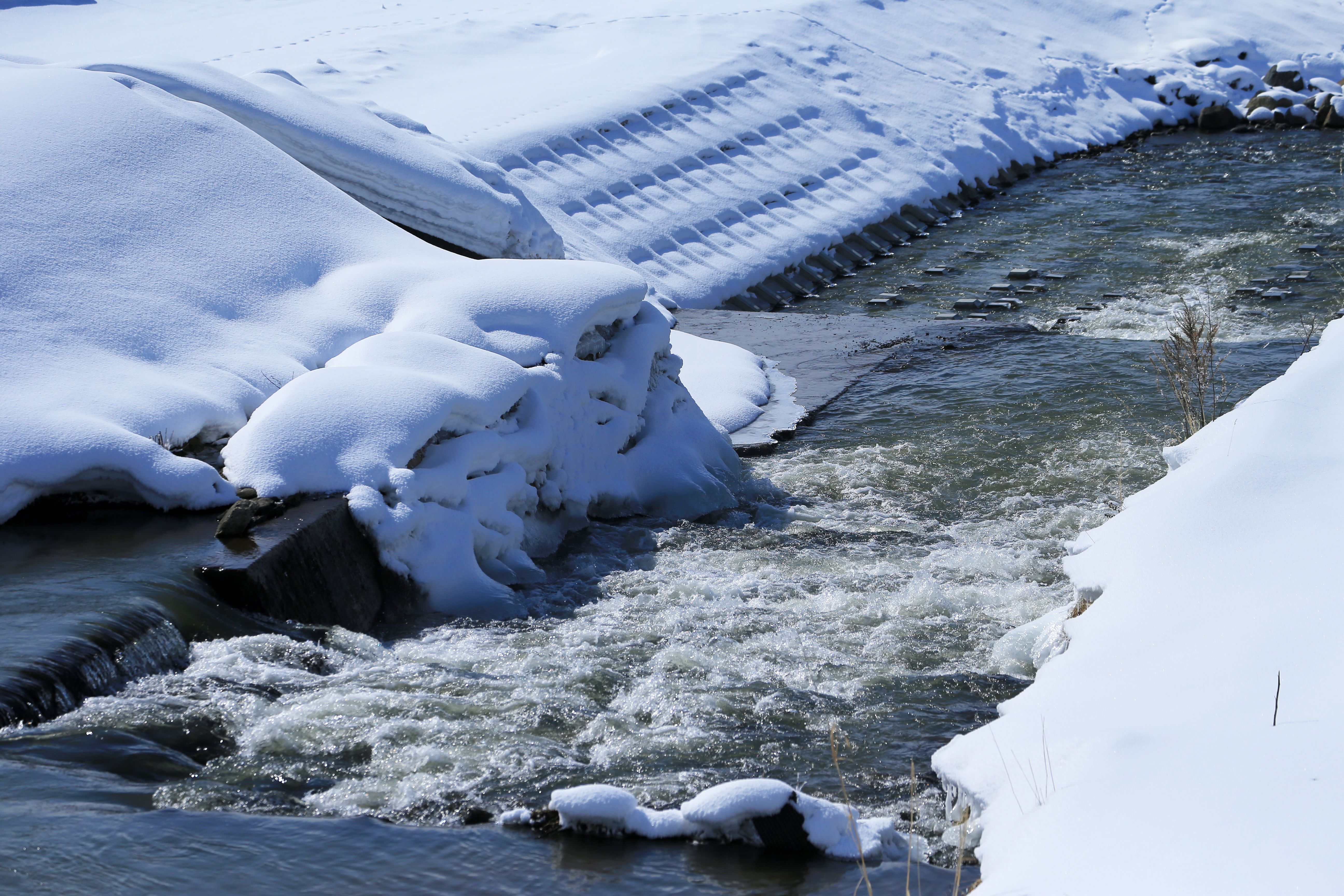 Scenic Winter Stream with Snow-Covered Banks · Free Stock Photo