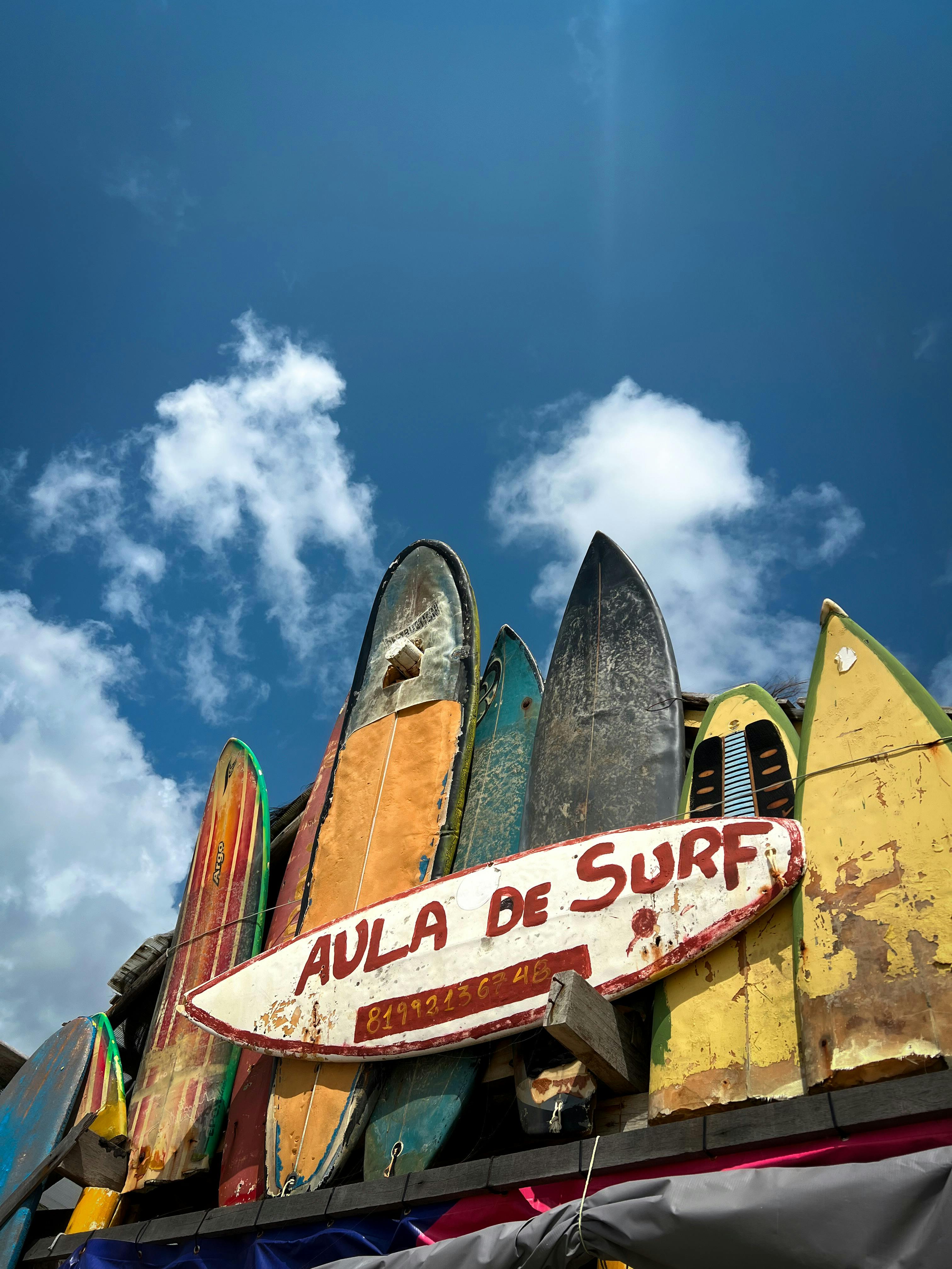 Tablas De Surf Coloridas Con Letrero Bajo Un Cielo Azul · Foto de stock ...