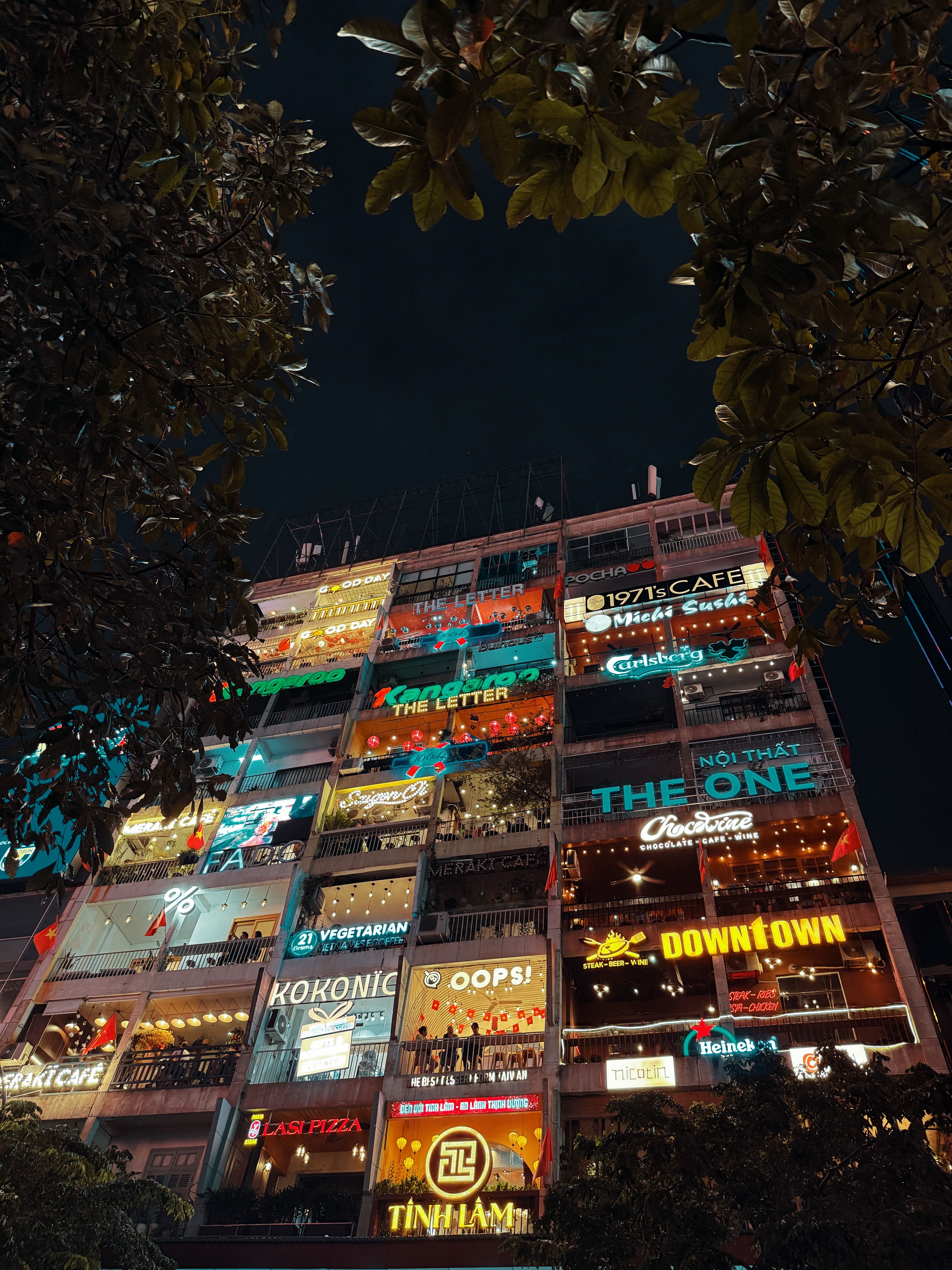 Vibrant Night Scene of Illuminated Cafe Building · Free Stock Photo