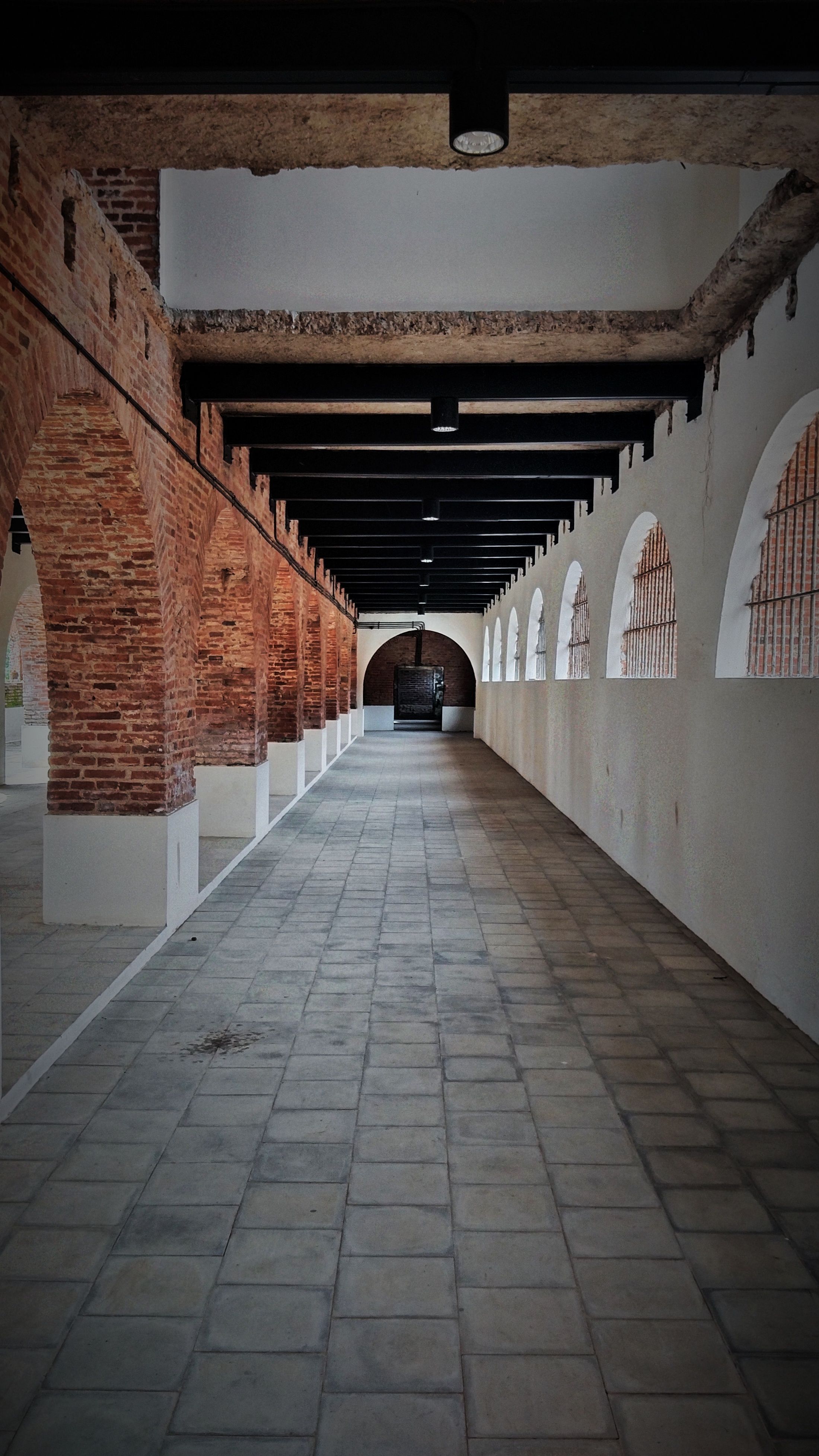 Historic Brick Corridor with Arched Windows · Free Stock Photo