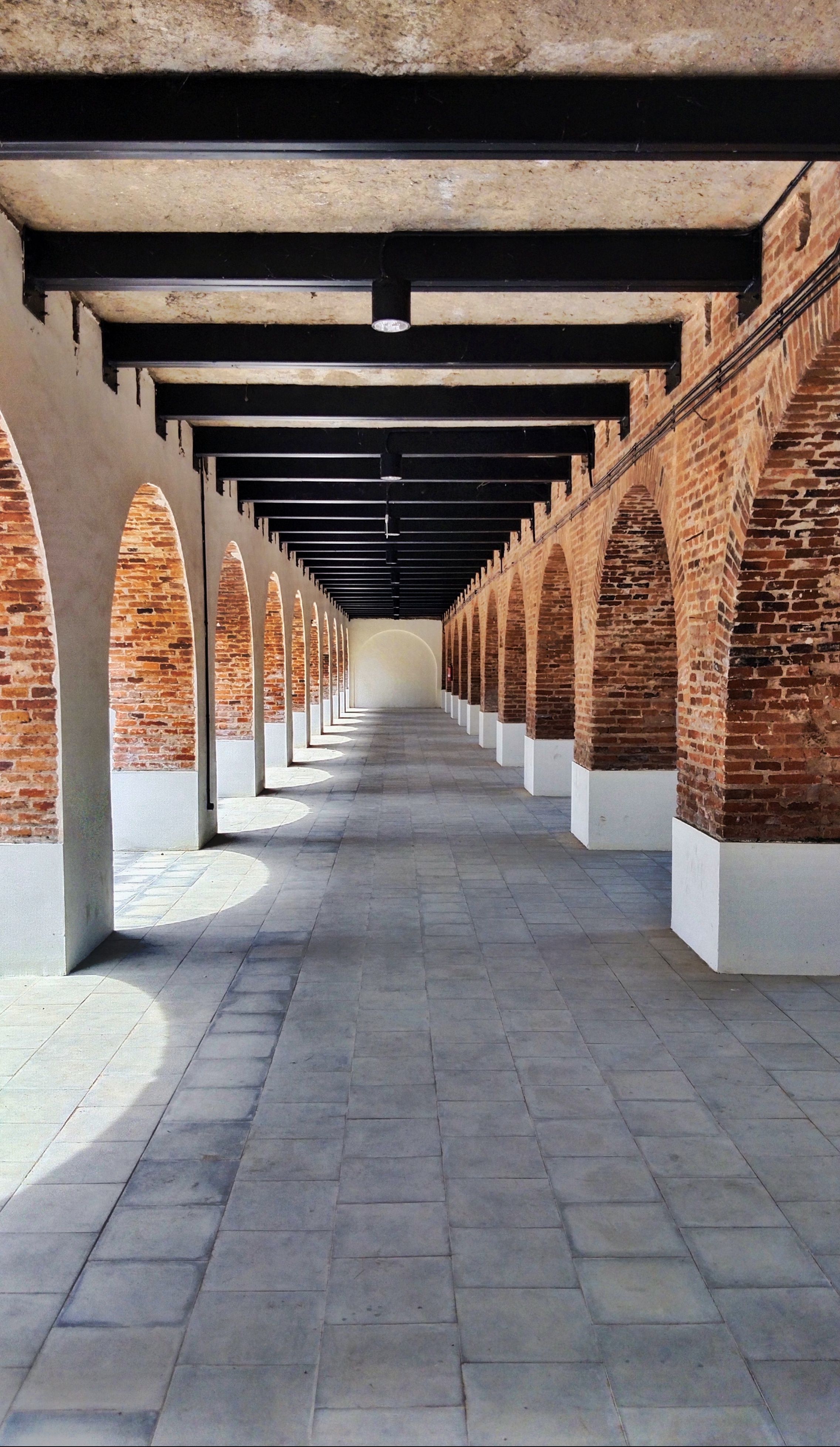 Historic Architectural Brick Corridor with Arches · Free Stock Photo
