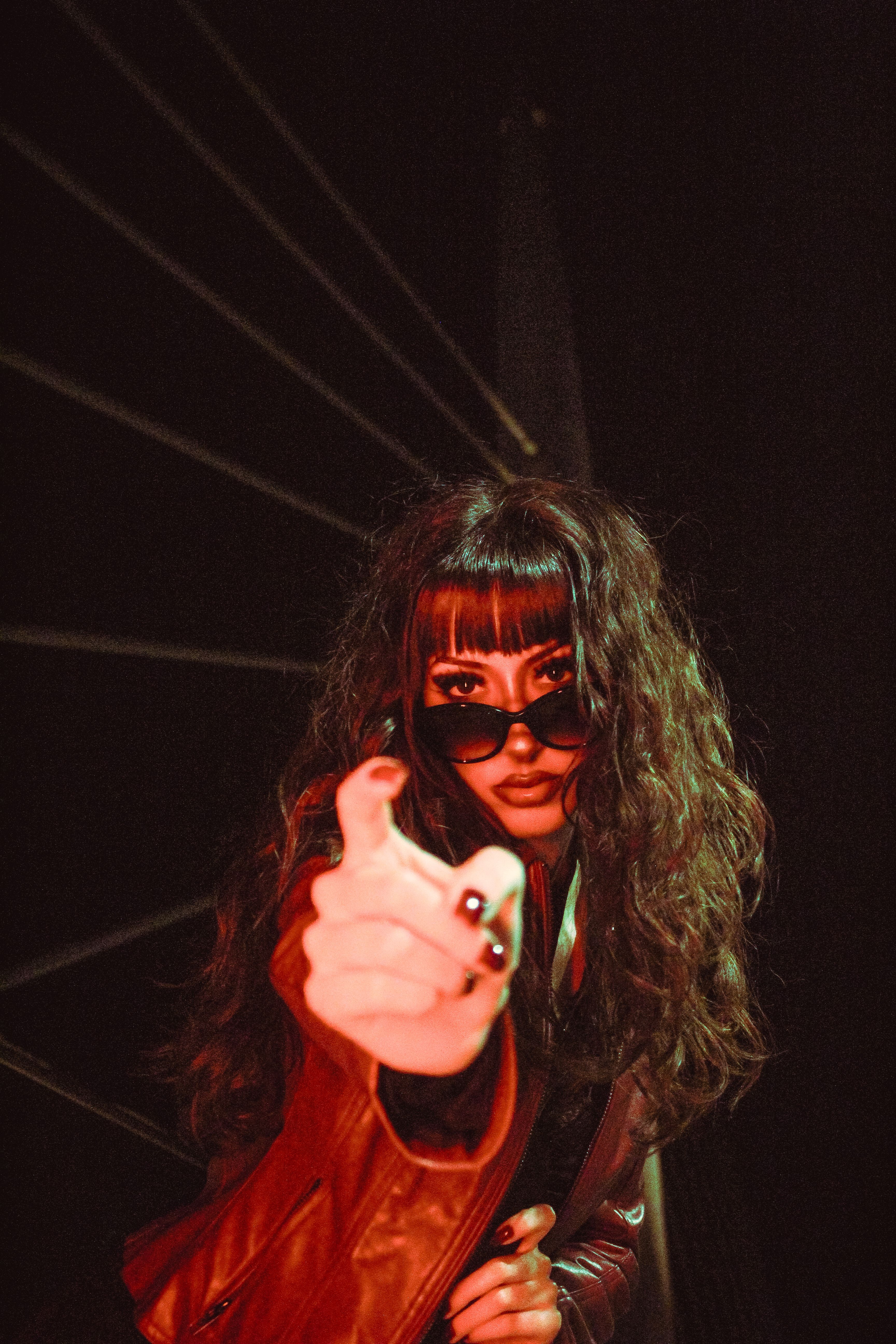 Mysterious Woman Pointing in Dramatic Lighting · Free Stock Photo