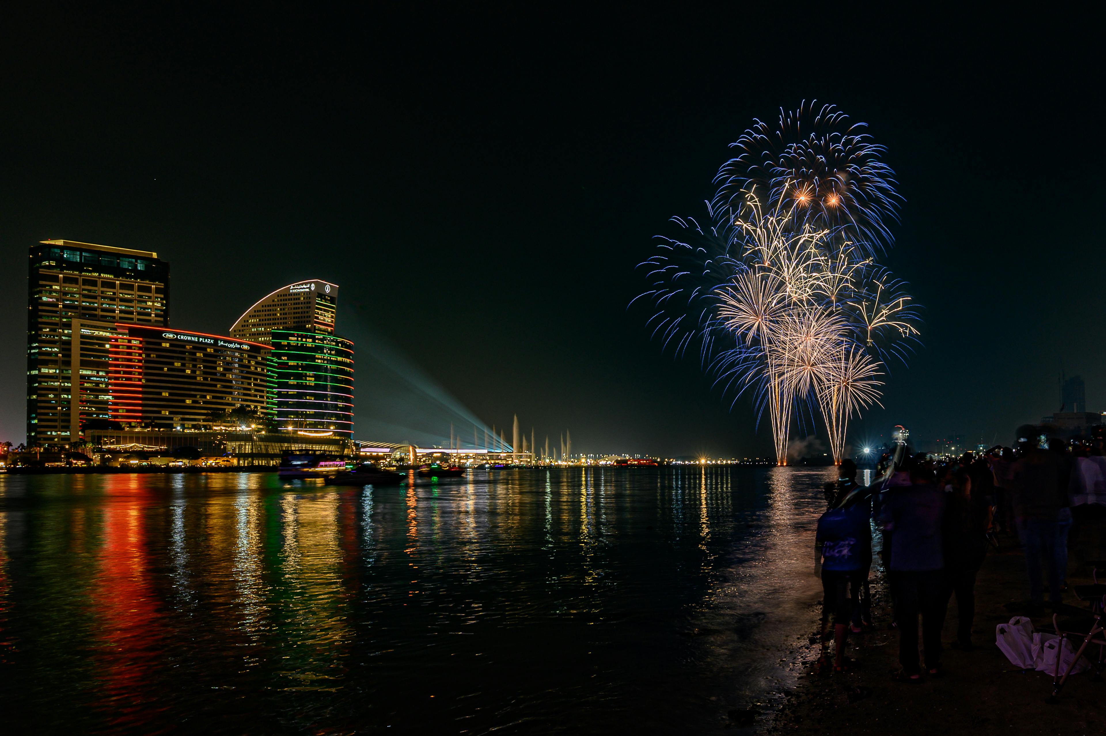 Spectacular Nighttime Fireworks Over City Waterfront · Free Stock Photo