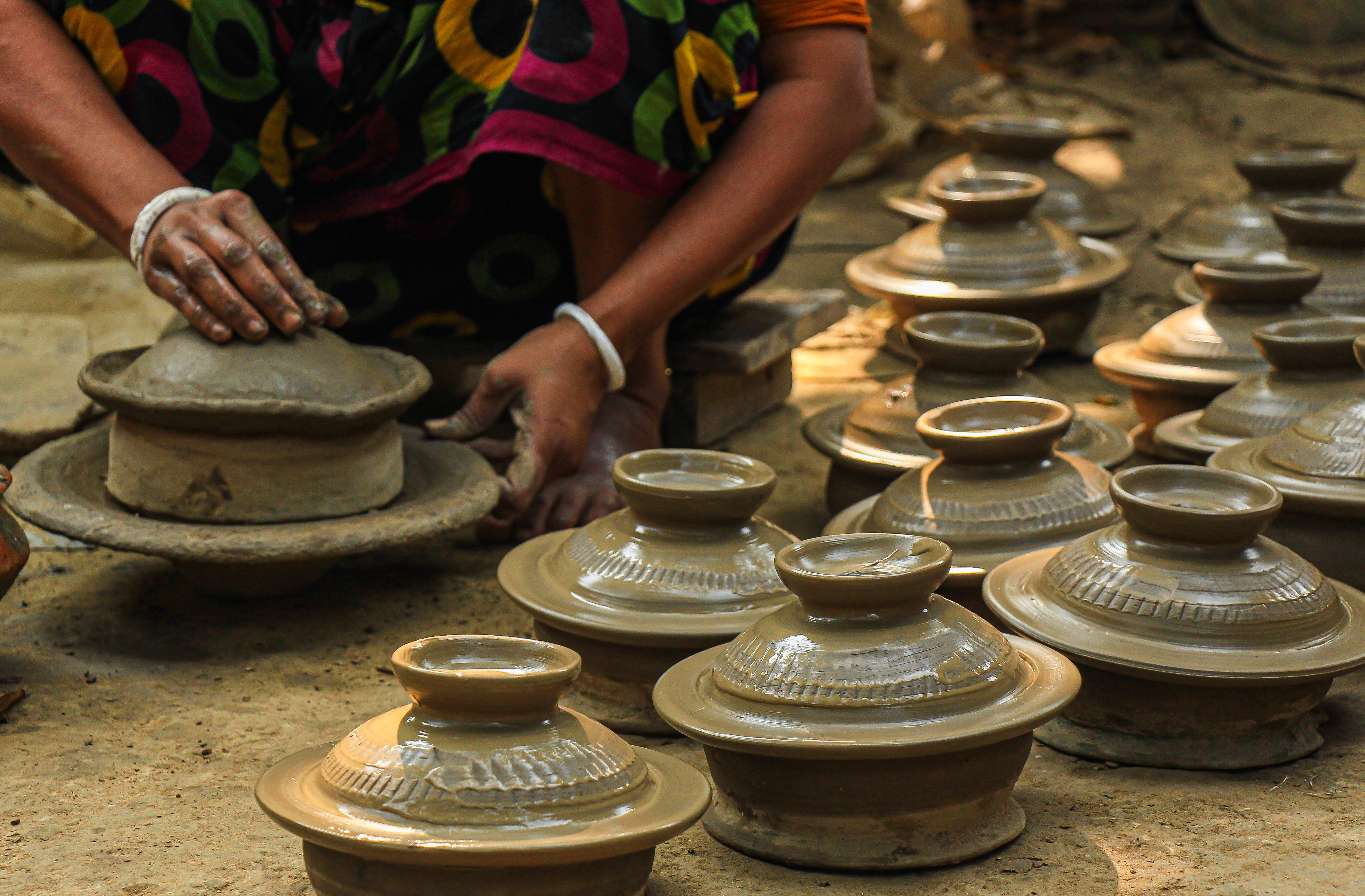 Artisan crafting traditional clay pots outdoors · Free Stock Photo