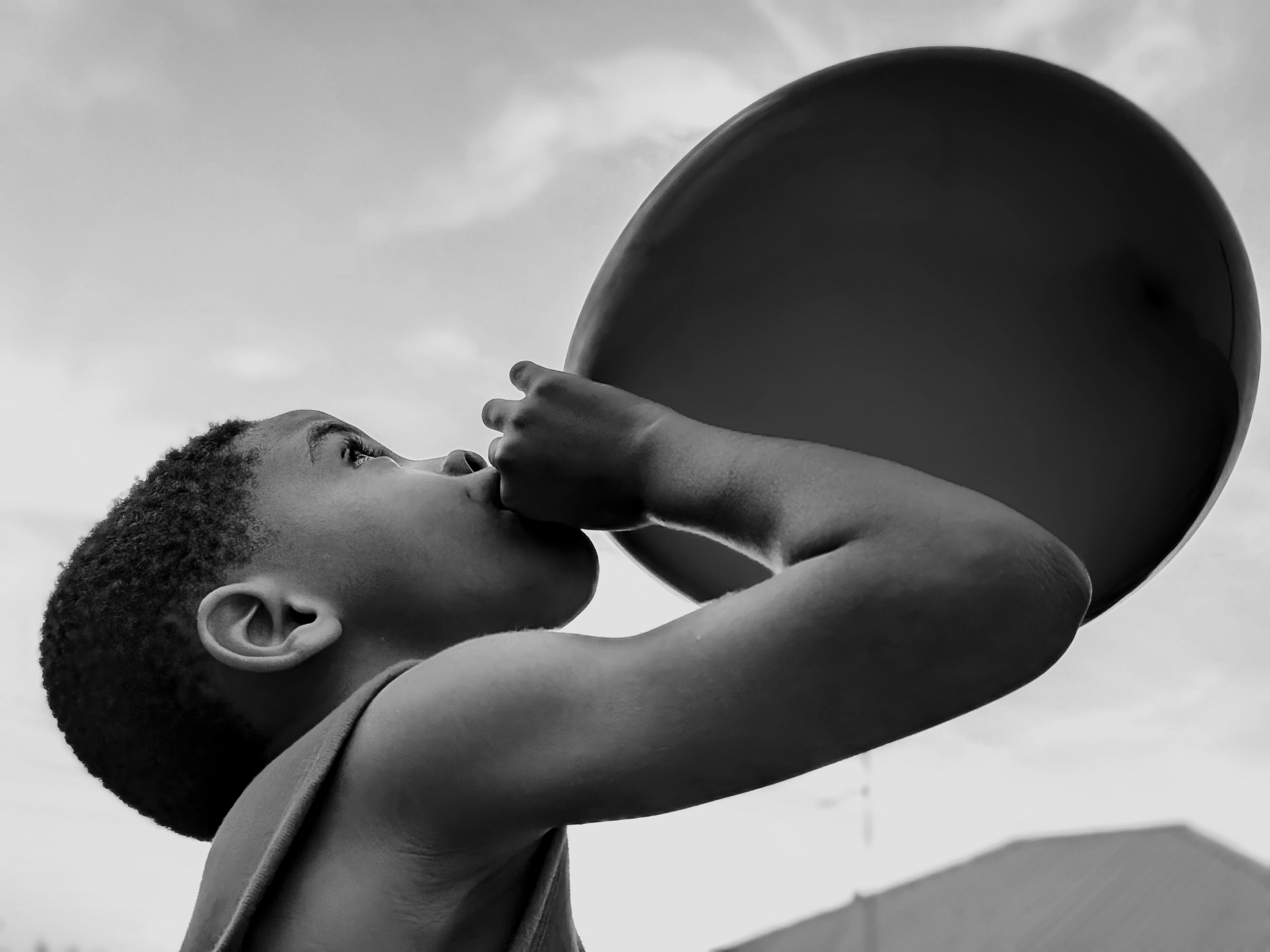 Joyful Moment of a Child Blowing a Balloon · Free Stock Photo