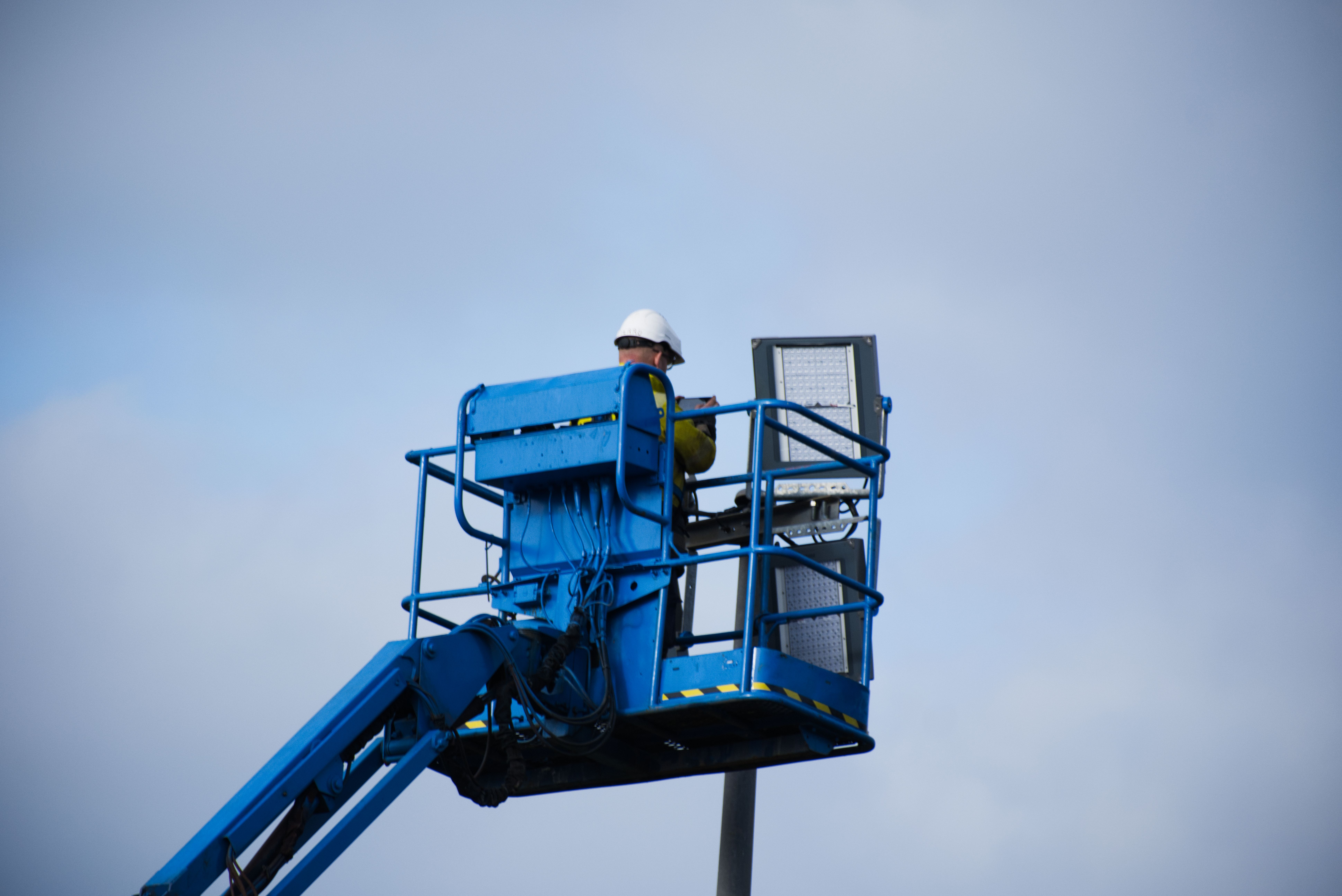 Worker in Lift Performing Maintenance Outdoors · Free Stock Photo