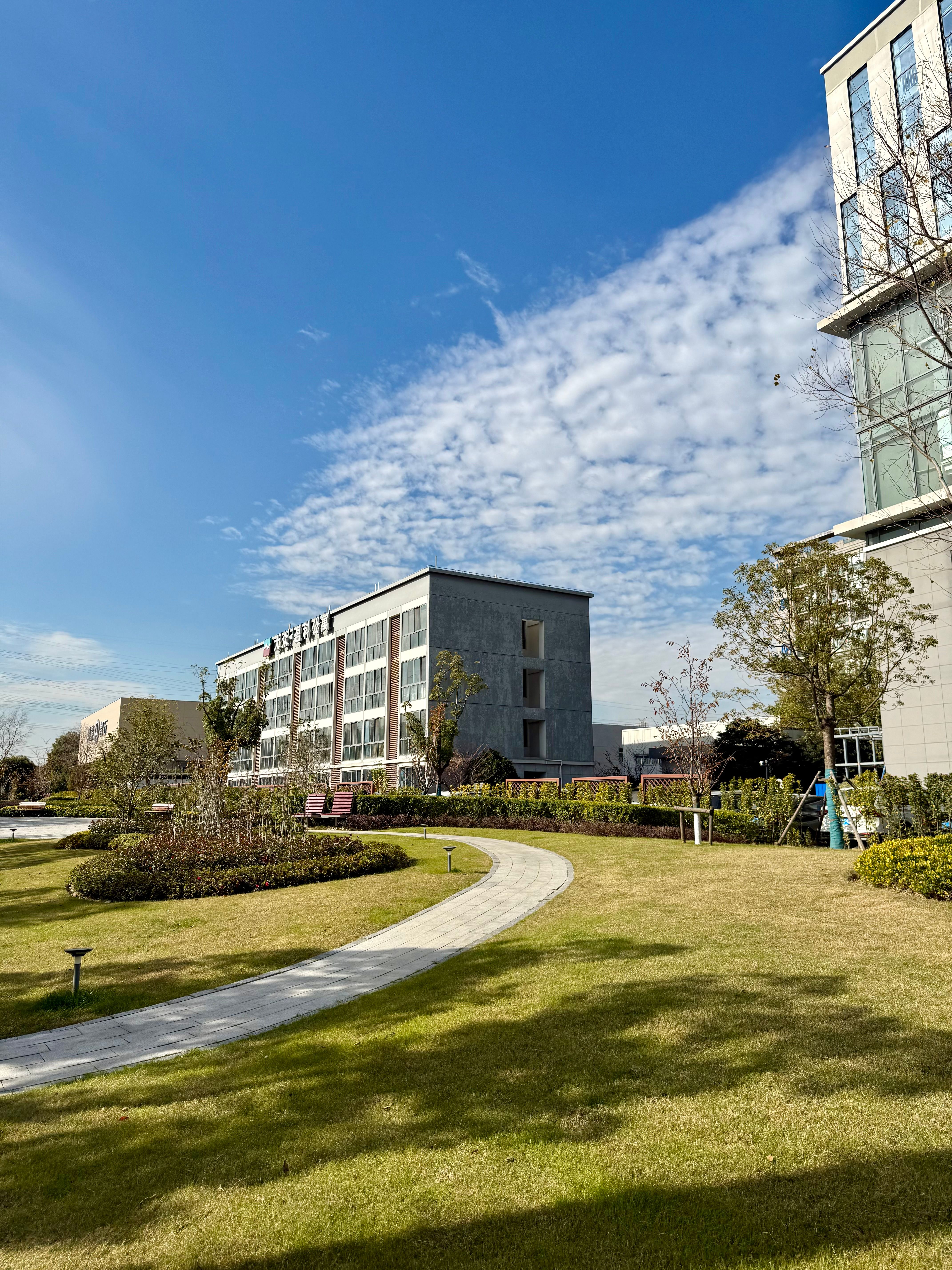 Modern Business Park with Green Spaces Under a Clear Sky · Free Stock Photo