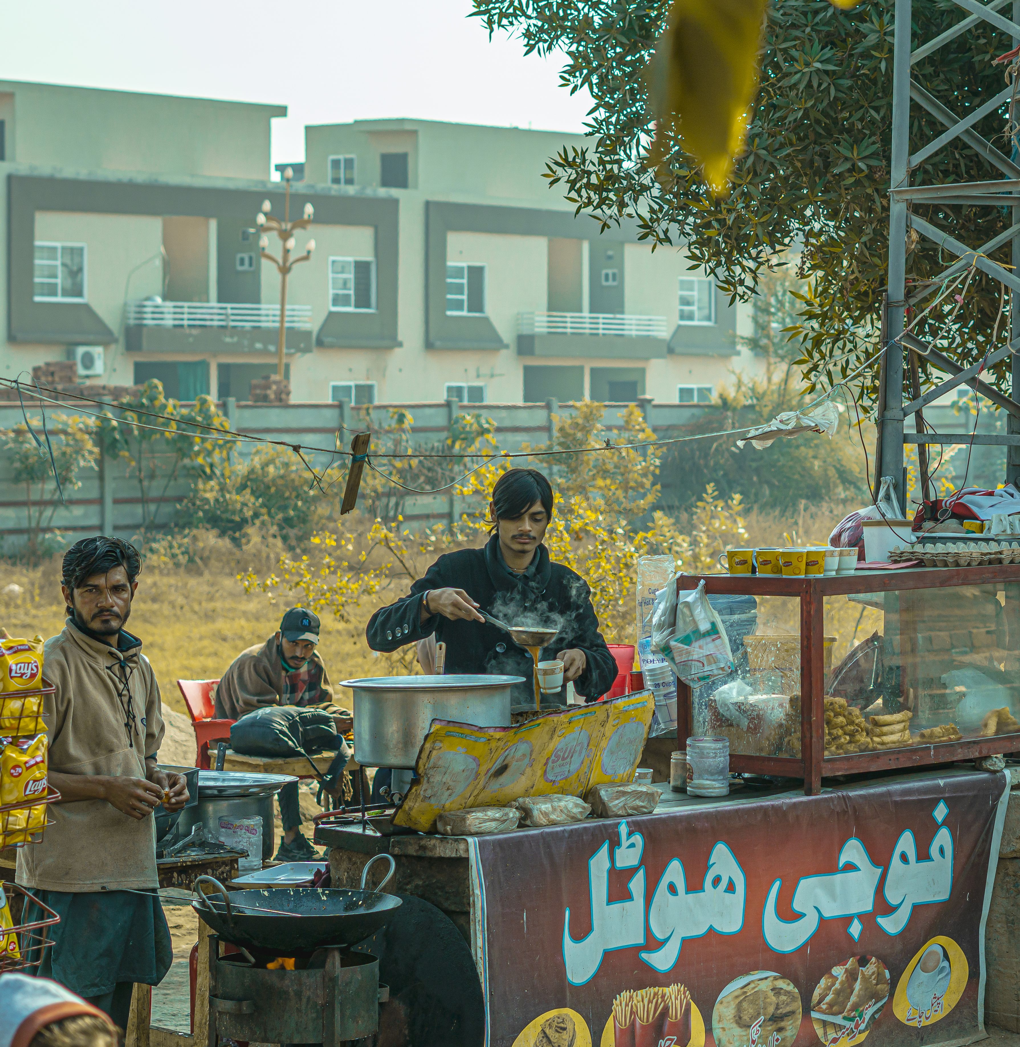 Lively Street Food Stall with Chefs and Customers · Free Stock Photo