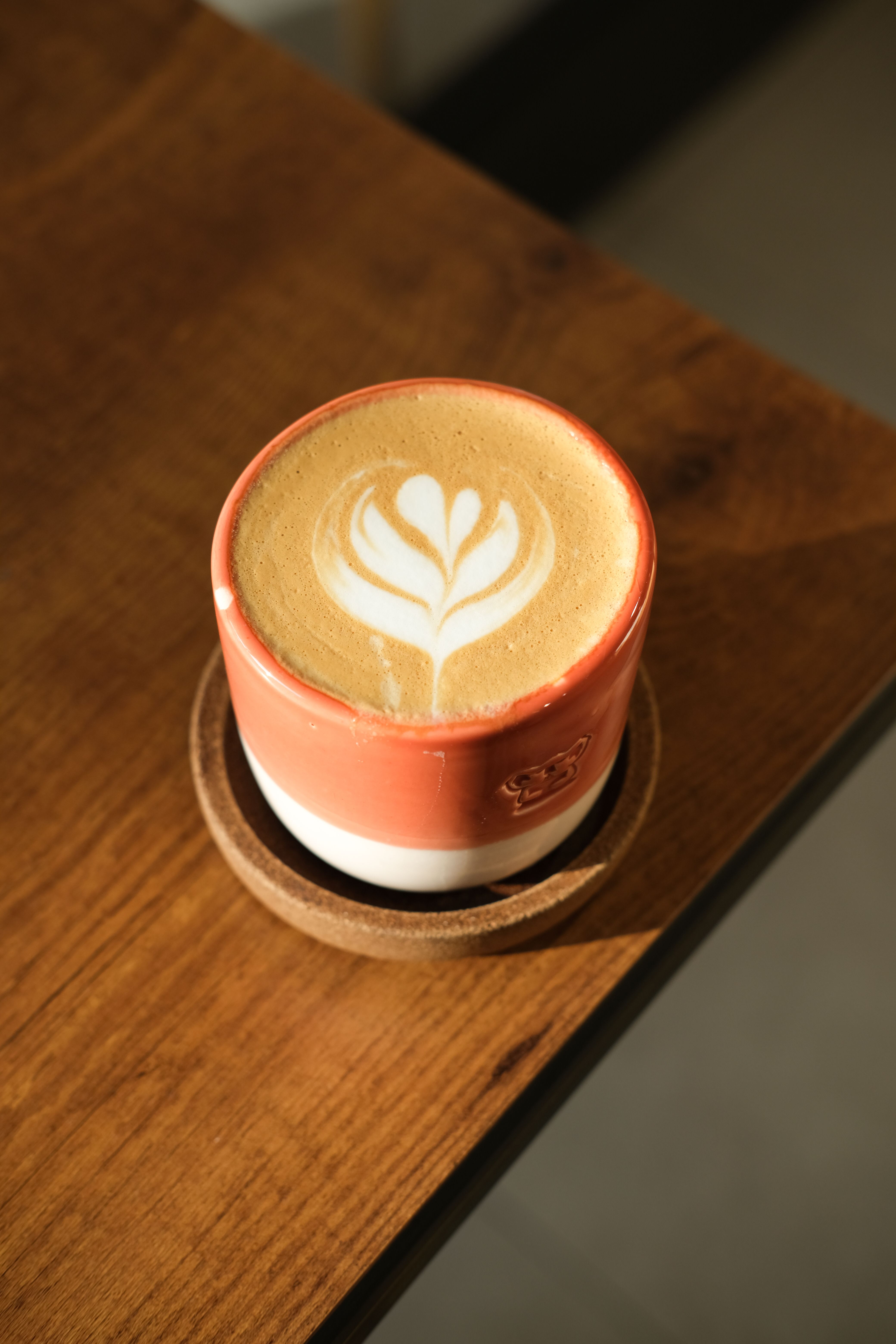 Elegant Latte Art in Sunlit Café Setting · Free Stock Photo
