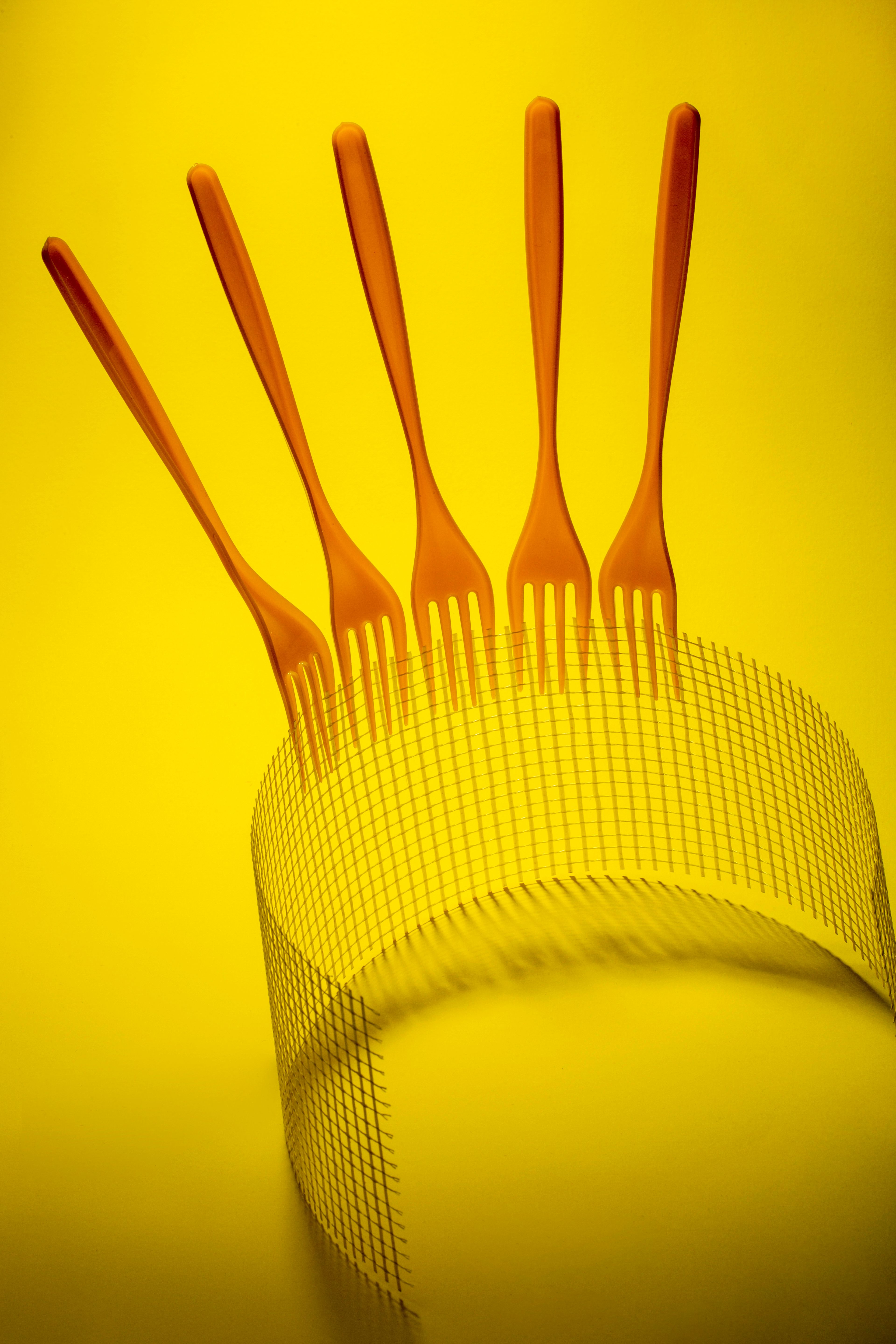 Abstract Yellow Plastic Forks on Vibrant Background · Free Stock Photo