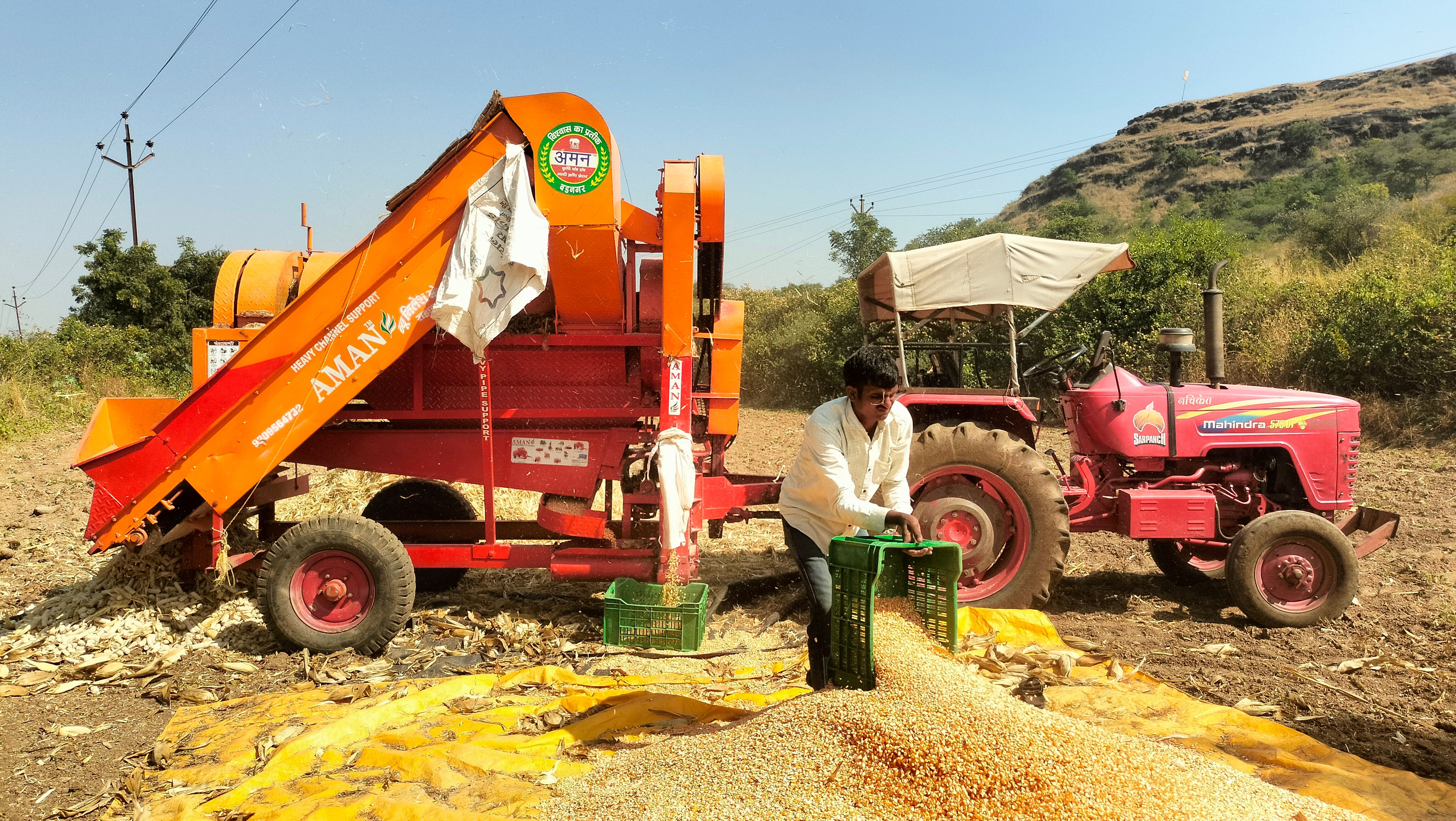 Indian Farmer Harvesting Corn with Machinery in Field · Free Stock Photo