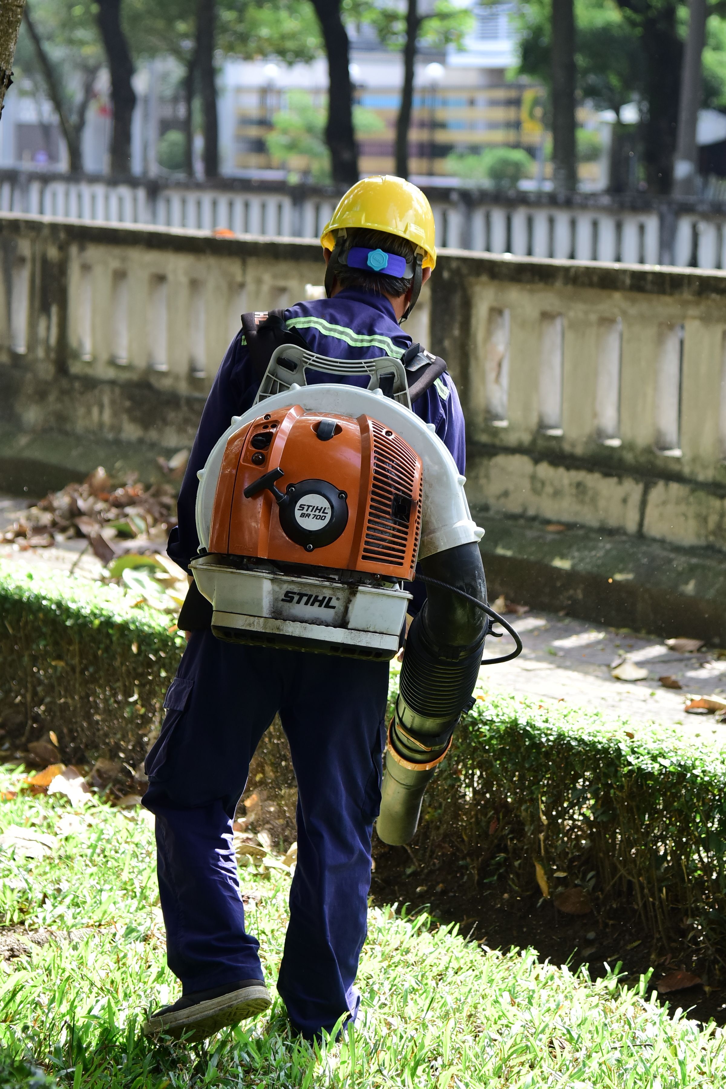 Worker Using Leaf Blower in Park Setting · Free Stock Photo