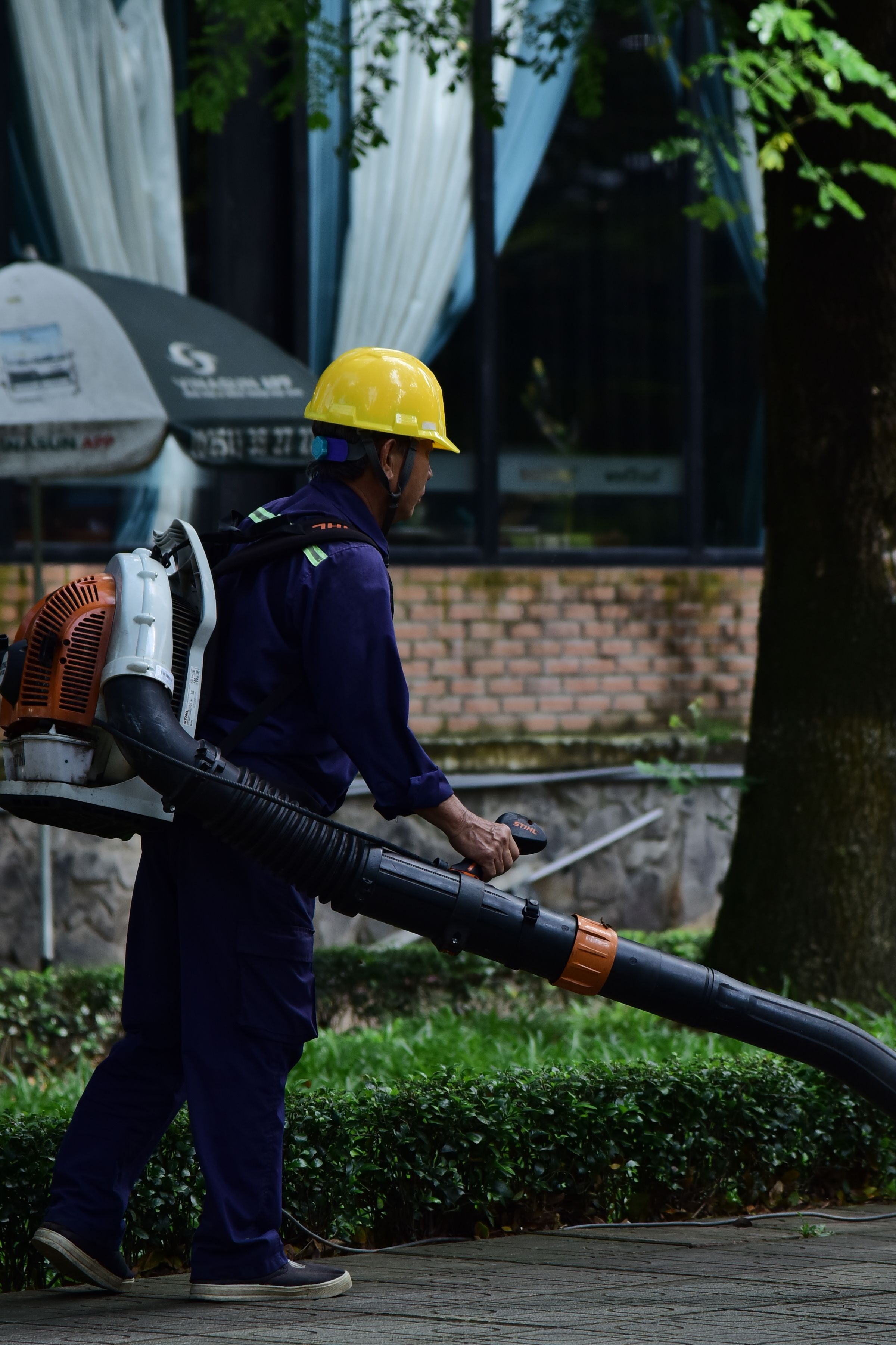 Gardener Using Leaf Blower in Urban Park · Free Stock Photo