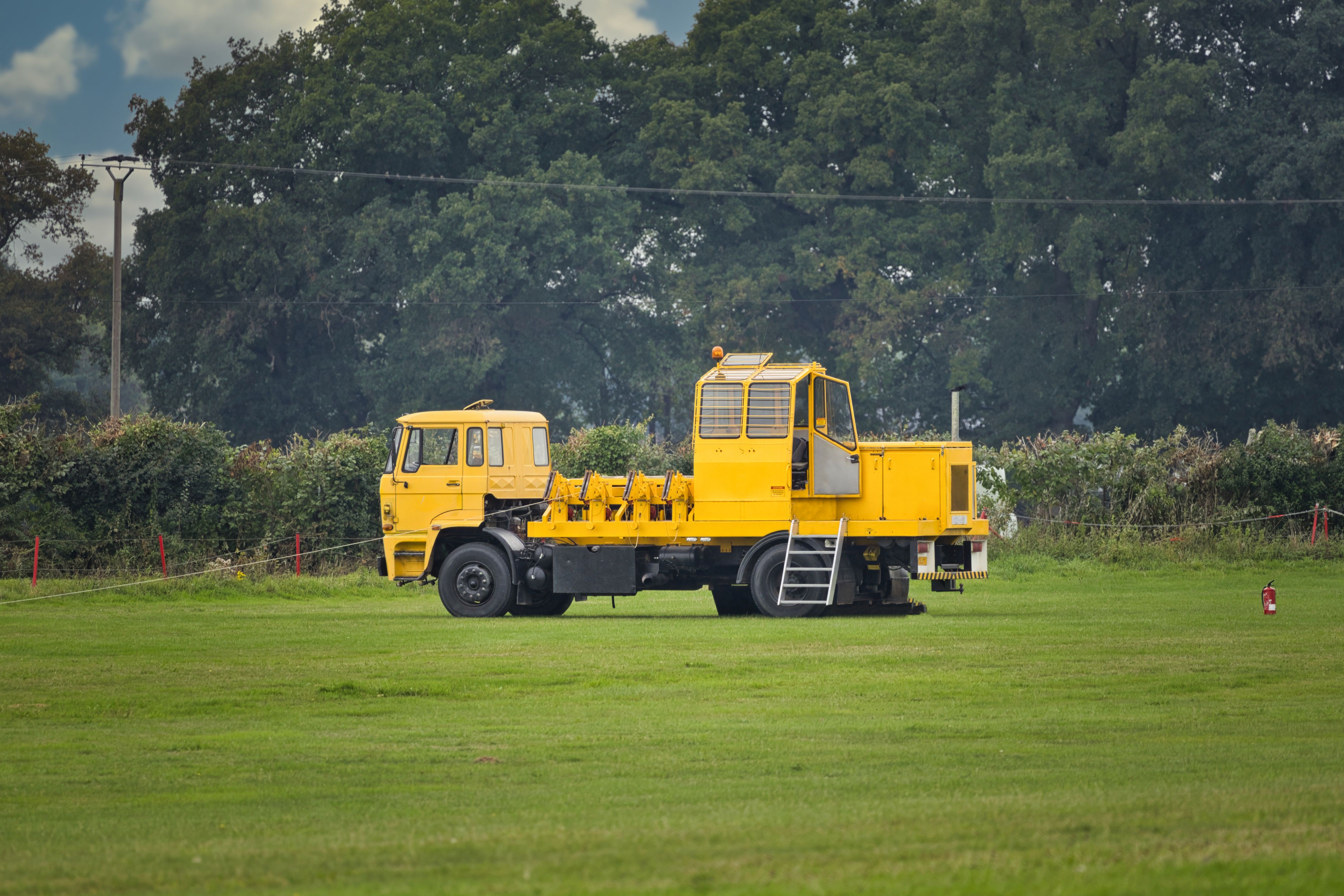 Yellow Utility Vehicle on Lush Green Field · Free Stock Photo