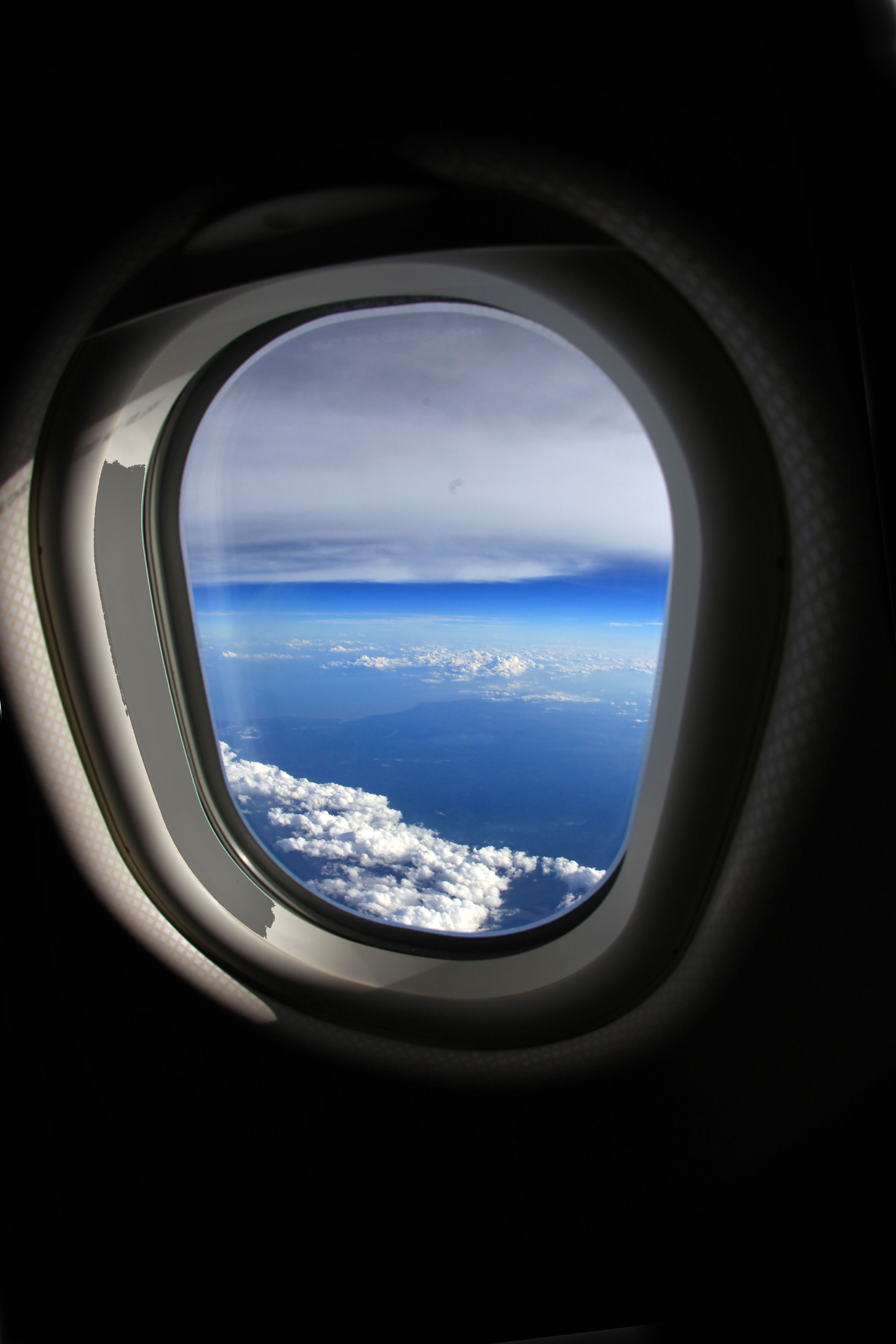 Mountains and Clouds Outside of an Airplane Window · Free Stock Photo
