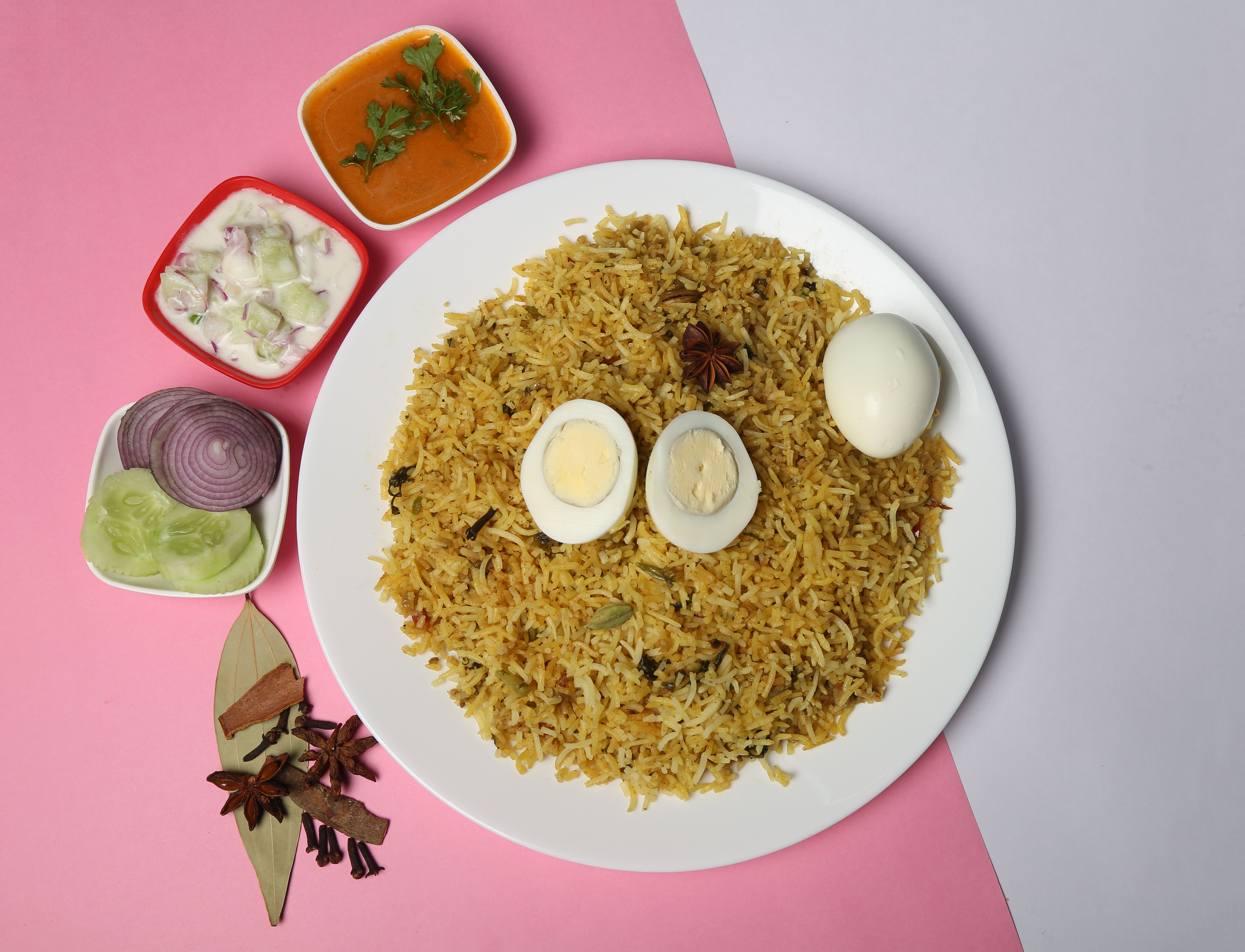 Delicious Egg Biryani with Sides on Pink Background · Free Stock Photo
