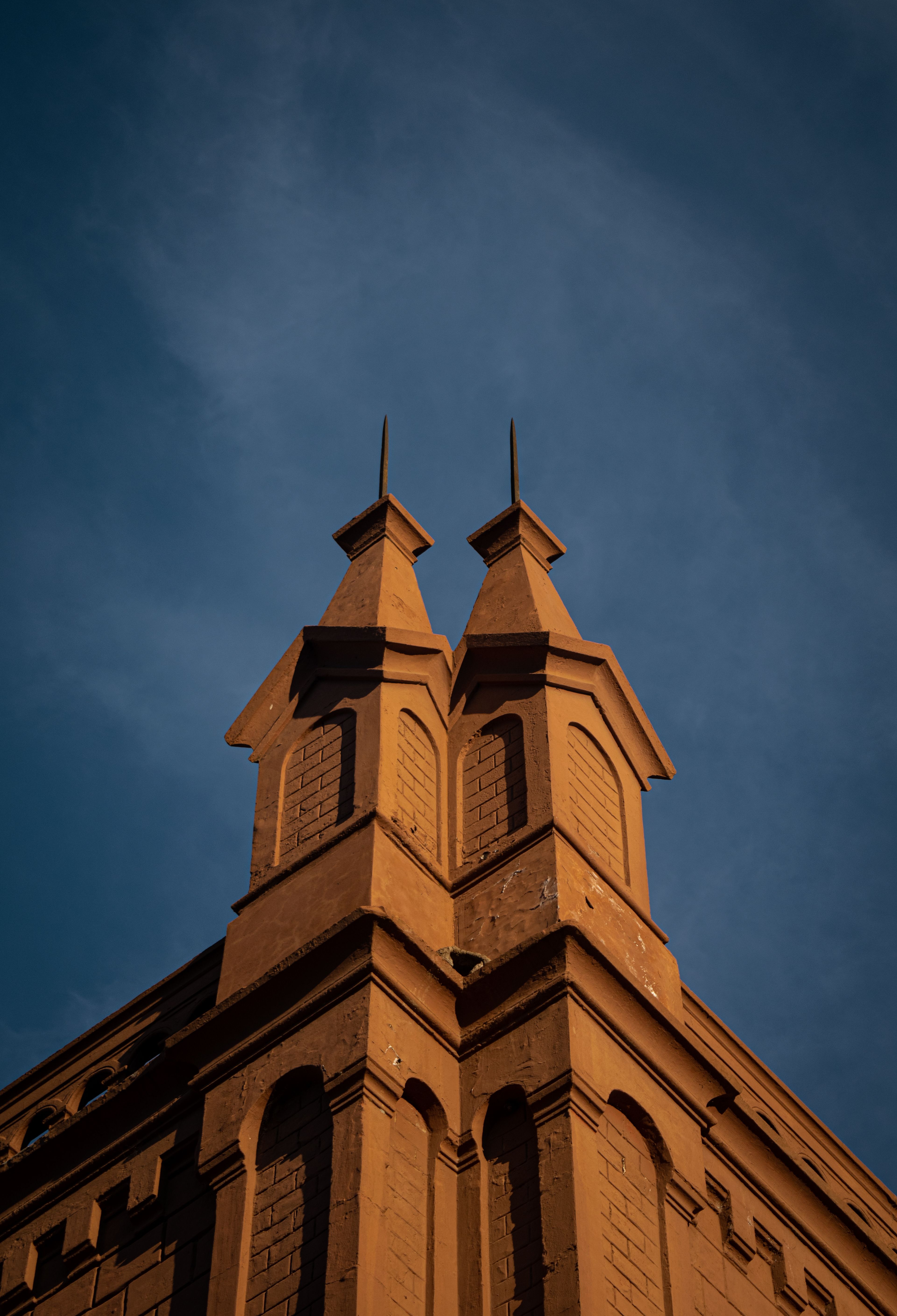 Elegant Brick Architectural Spires Against Blue Sky · Free Stock Photo