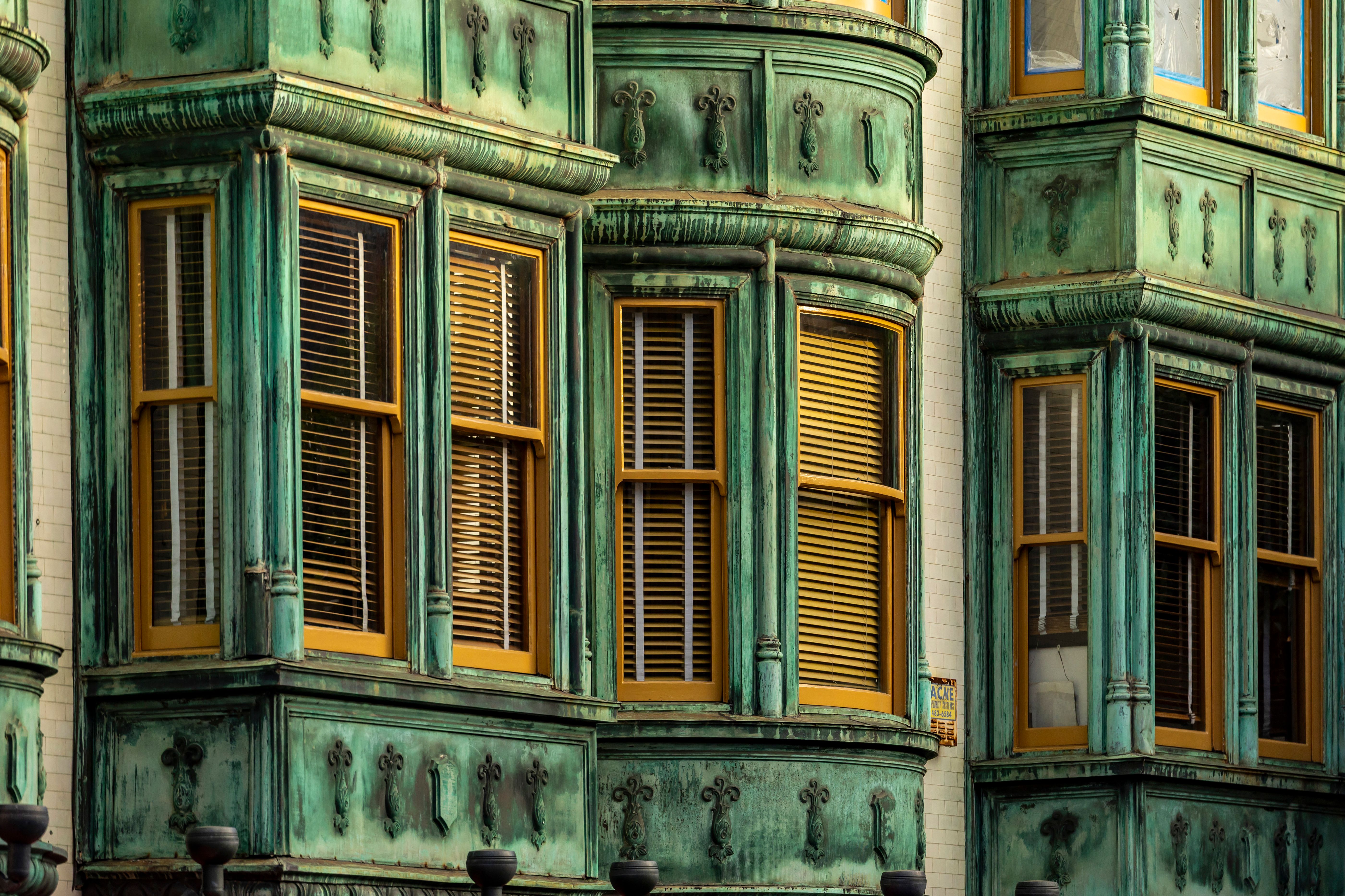 Vintage Green Building Facade with Bay Windows · Free Stock Photo