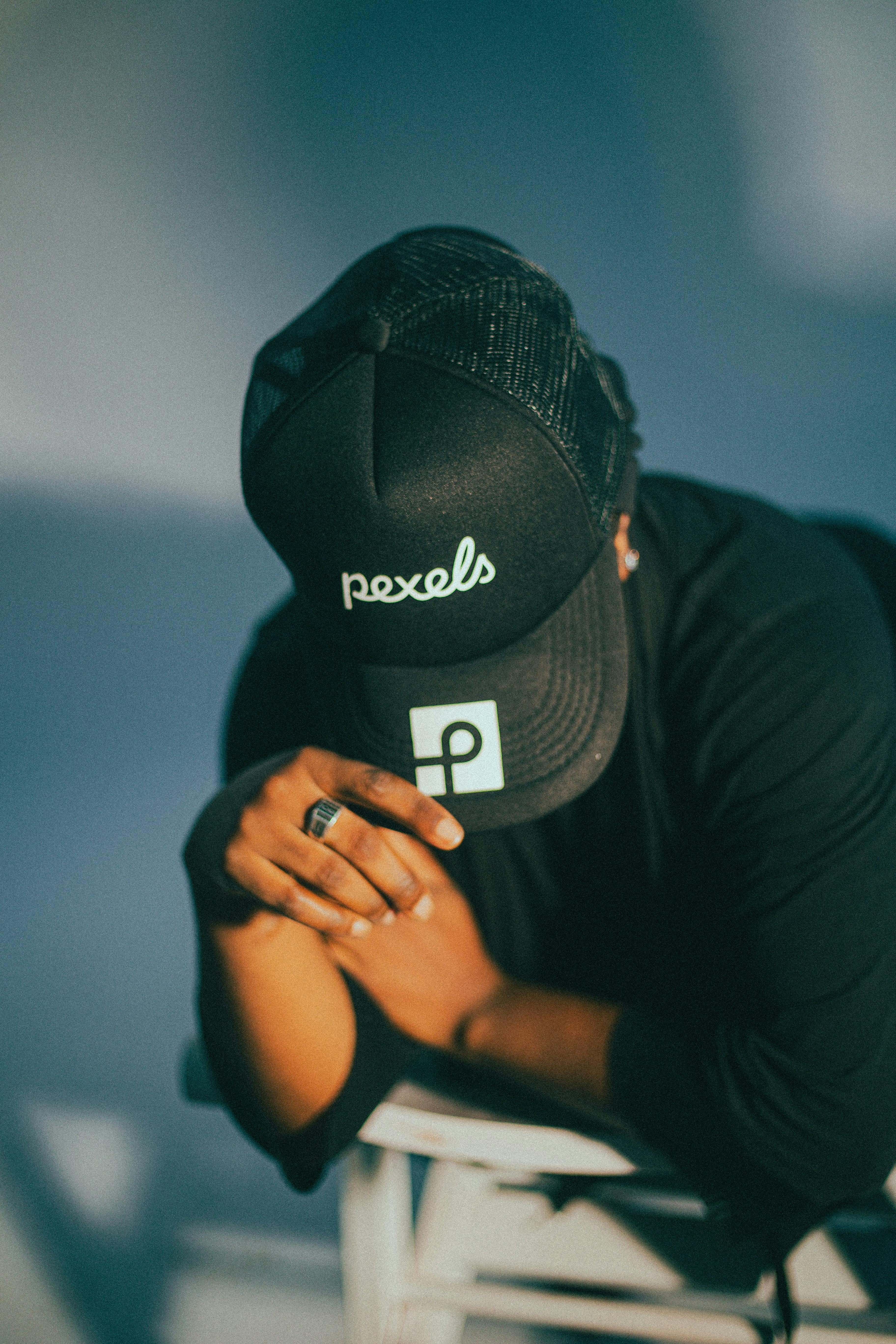 戴着品牌帽子的沉思者肖像 · 免费素材图片