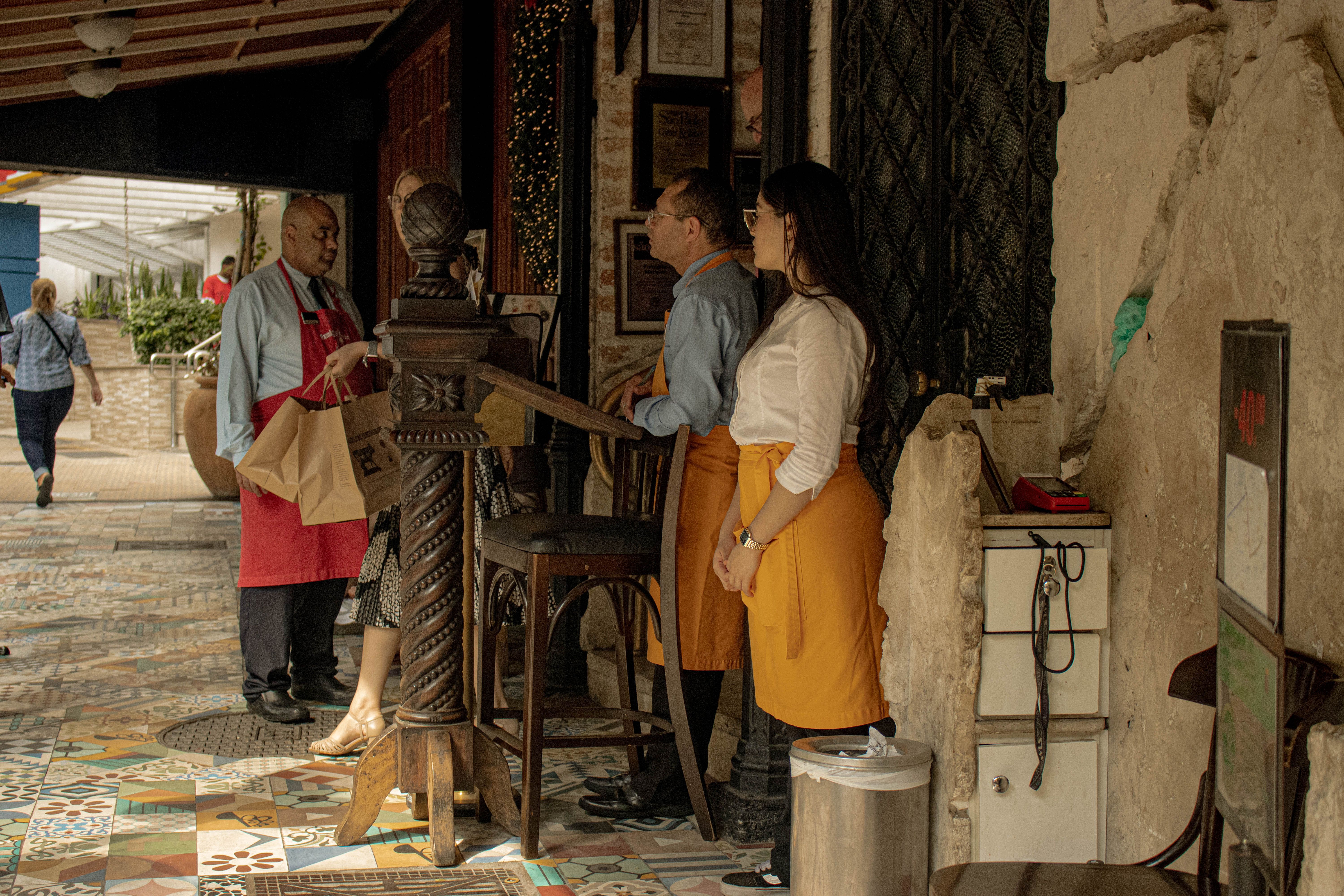Restaurant staff assisting customers at entrance · Free Stock Photo