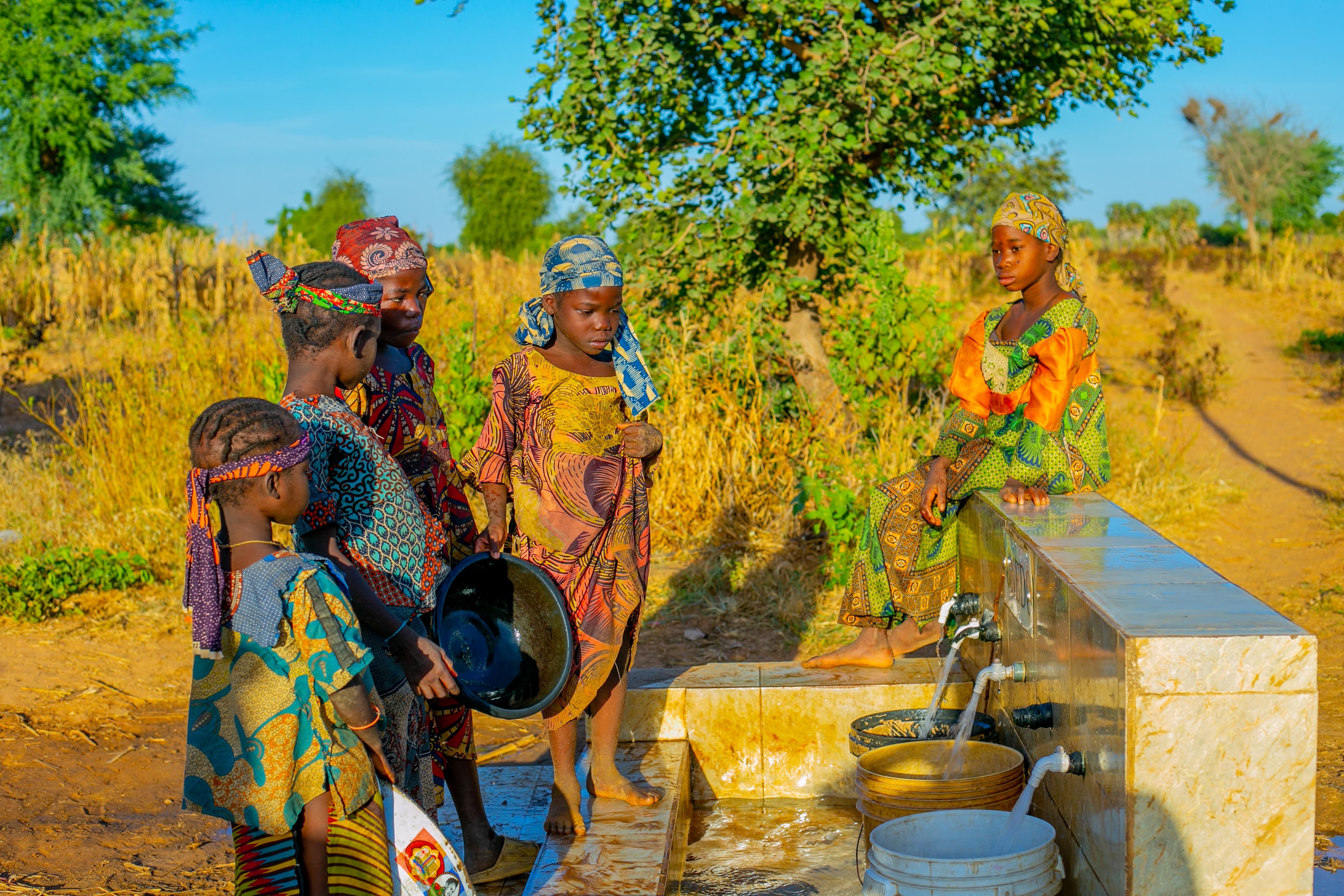 Children Gather at an Outdoor Water Tap in Vibrant Attire · Free Stock ...