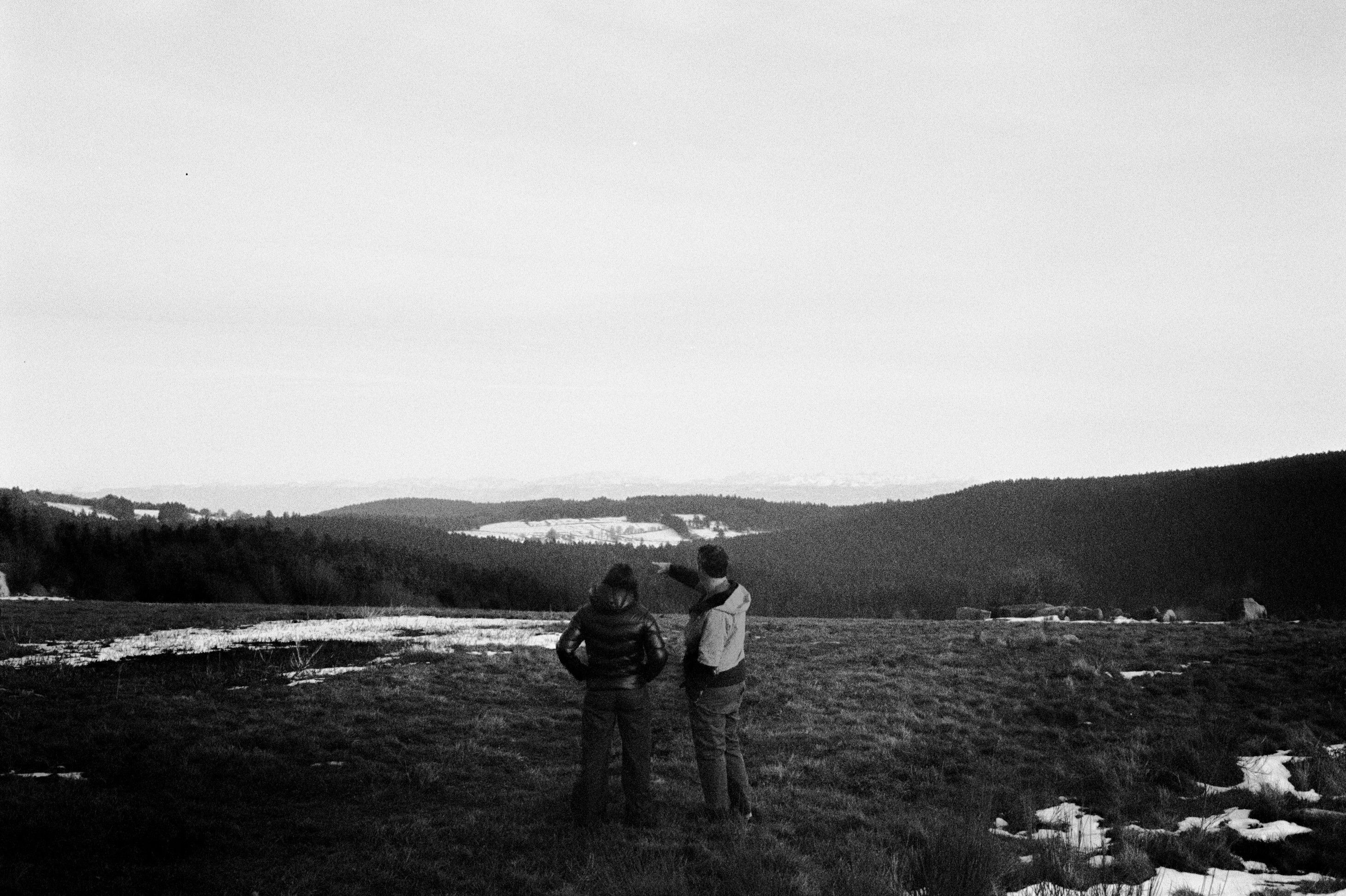 Black and White Landscape with Two People Observing · Free Stock Photo