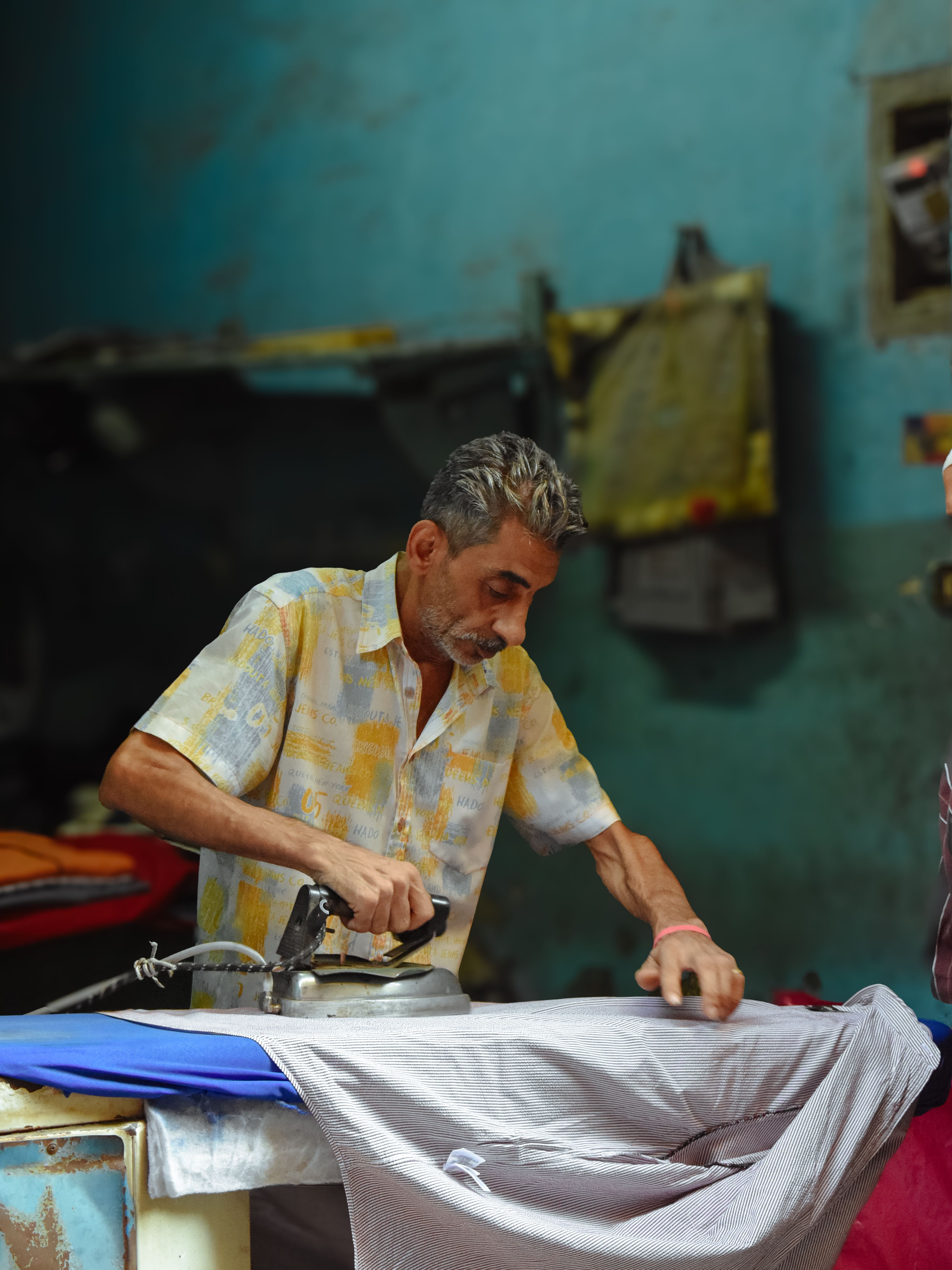Man Ironing Clothes in Traditional Workshop · Free Stock Photo