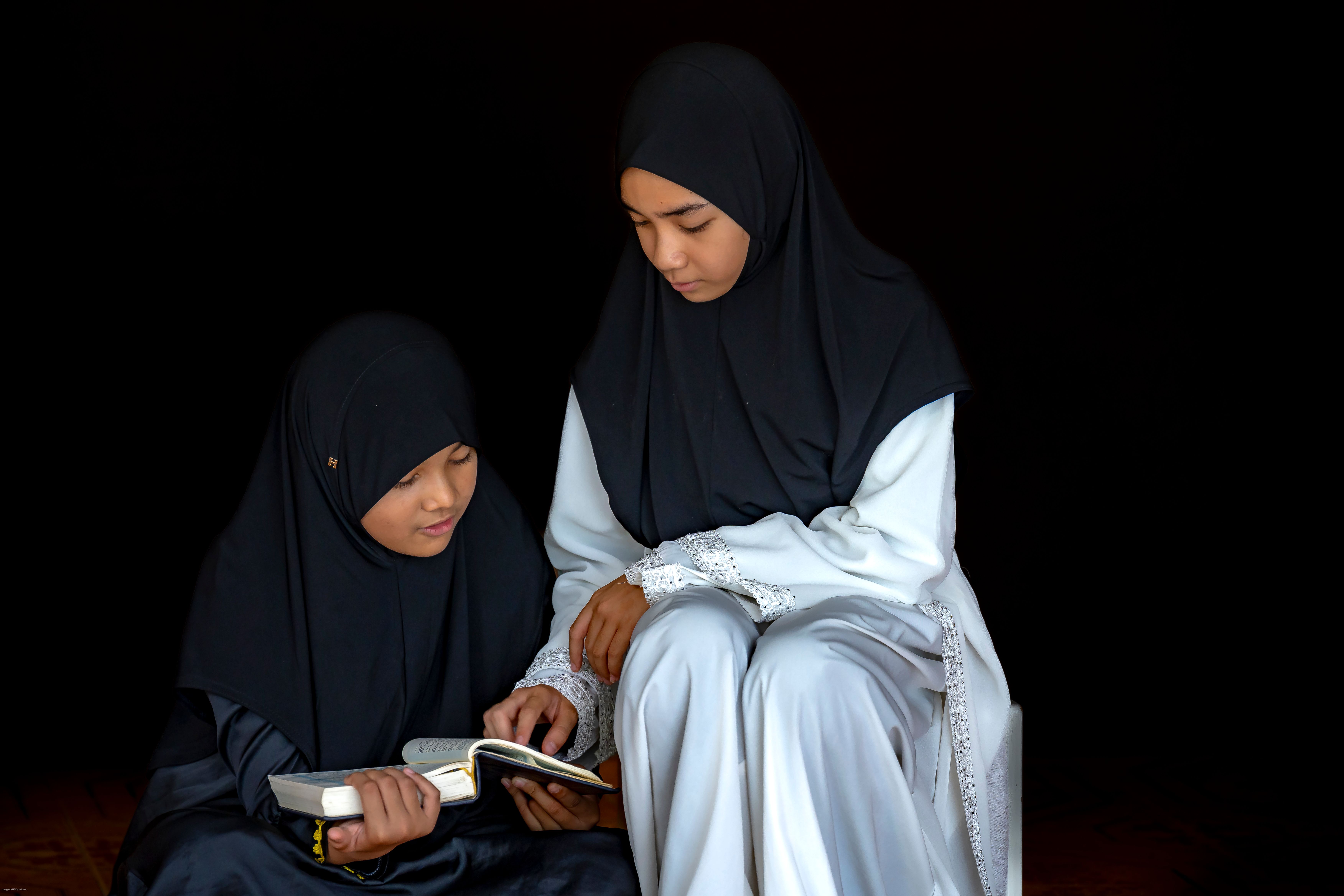 Two Young Women Reading Holy Book Together · Free Stock Photo