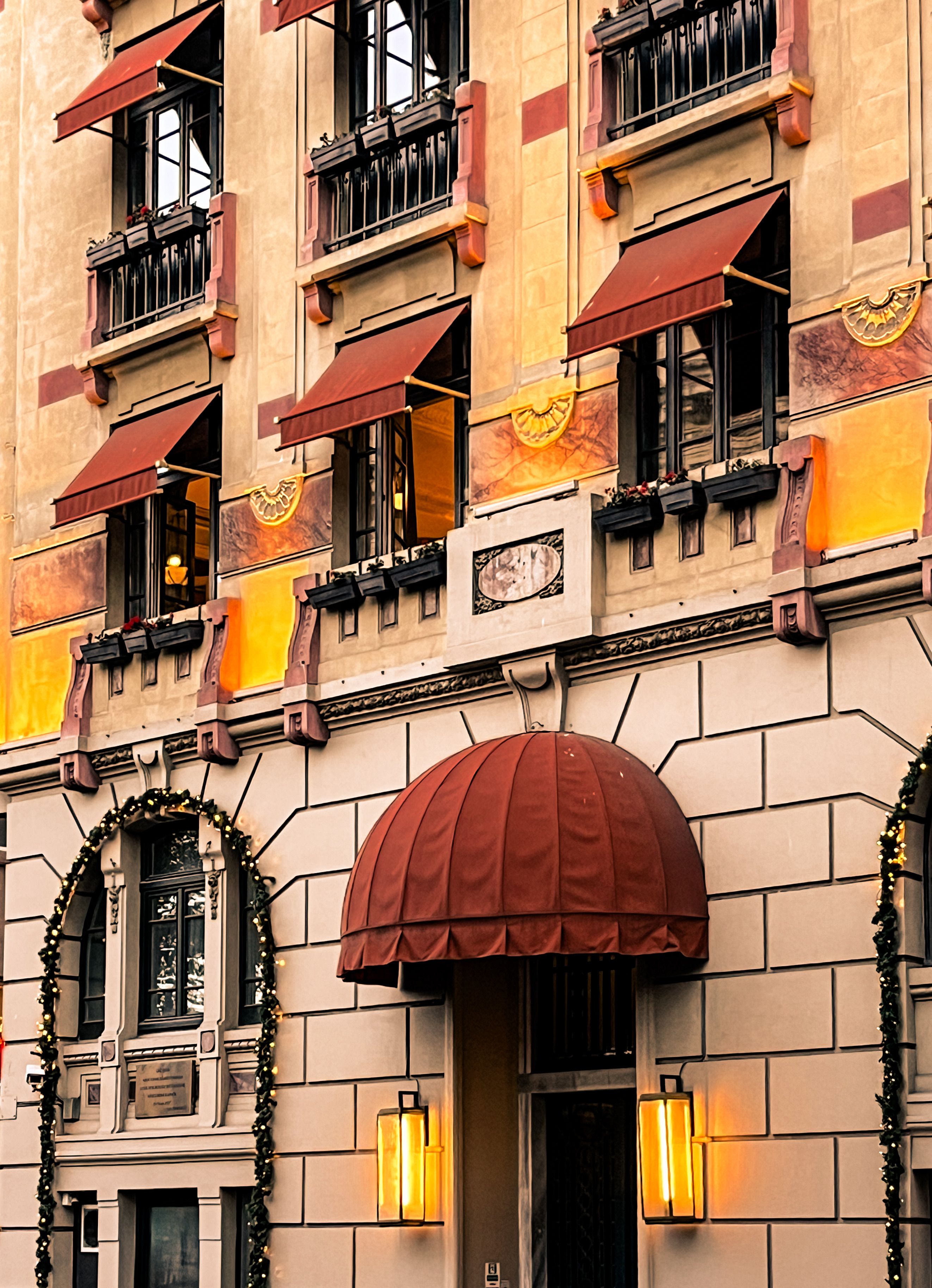 Elegant Urban Hotel Facade with Red Canopies · Free Stock Photo