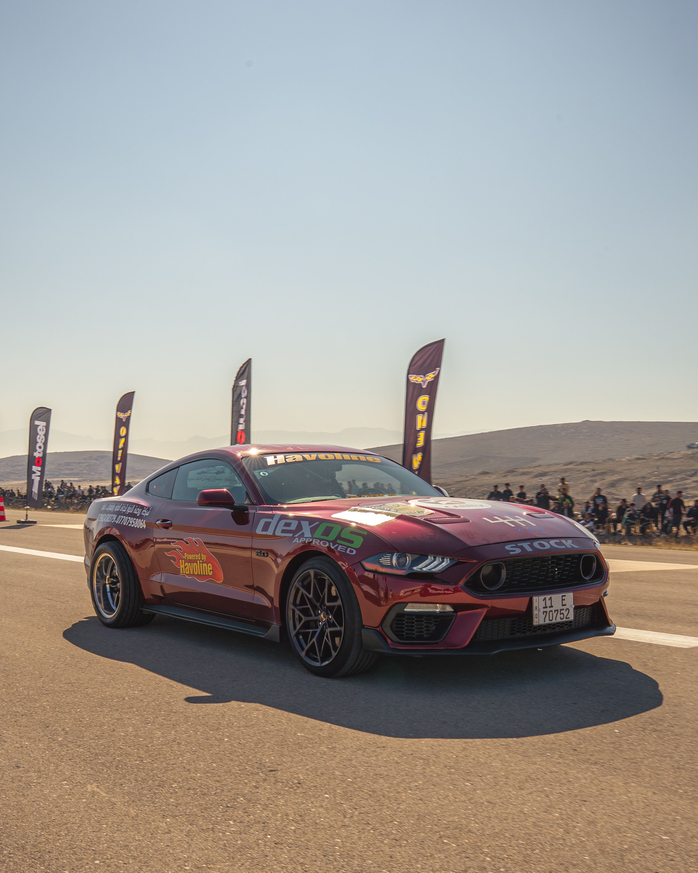 High-Speed Race Car on Desert Track with Crowd · Free Stock Photo