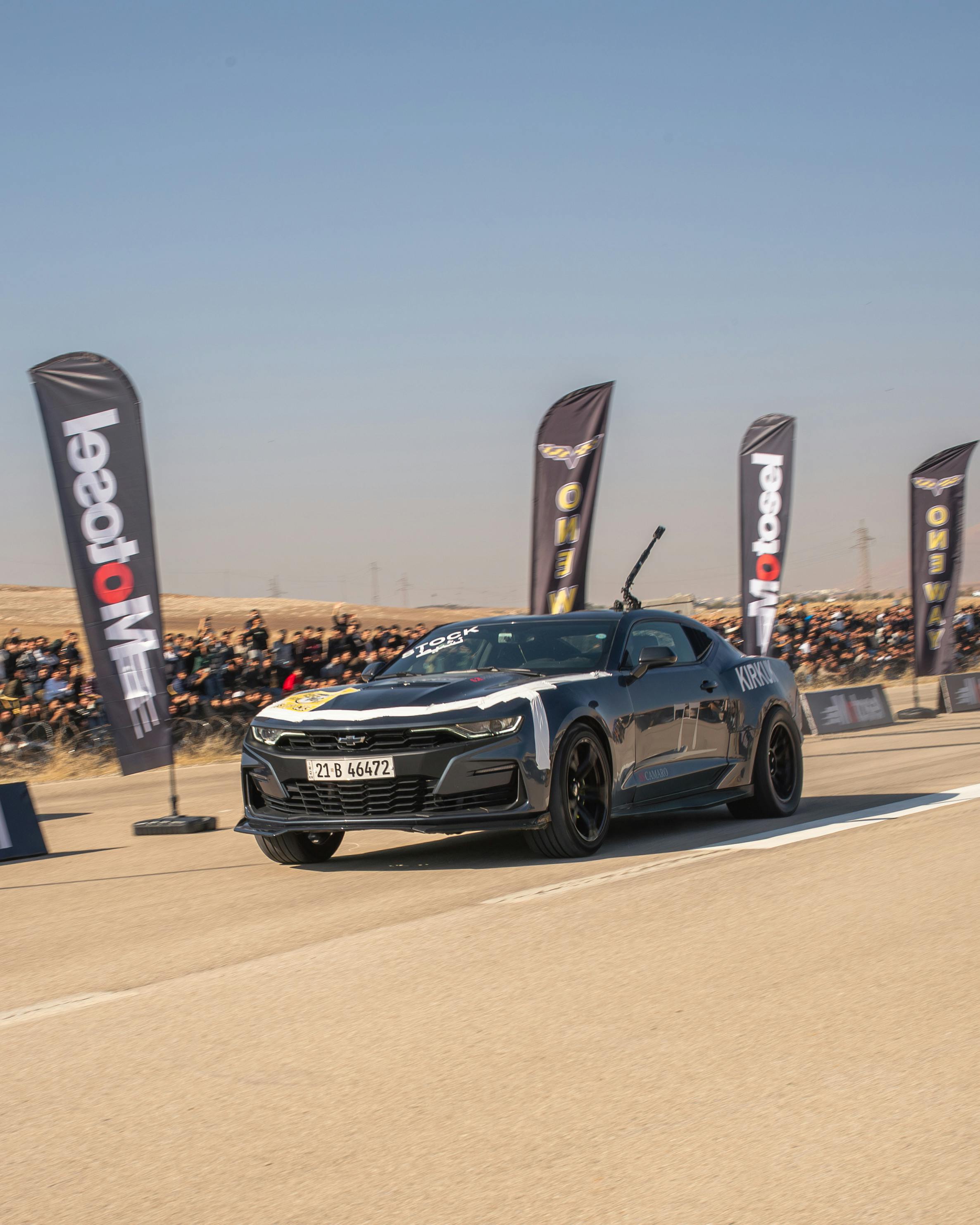 High-Speed Race Car on Desert Track with Crowd · Free Stock Photo
