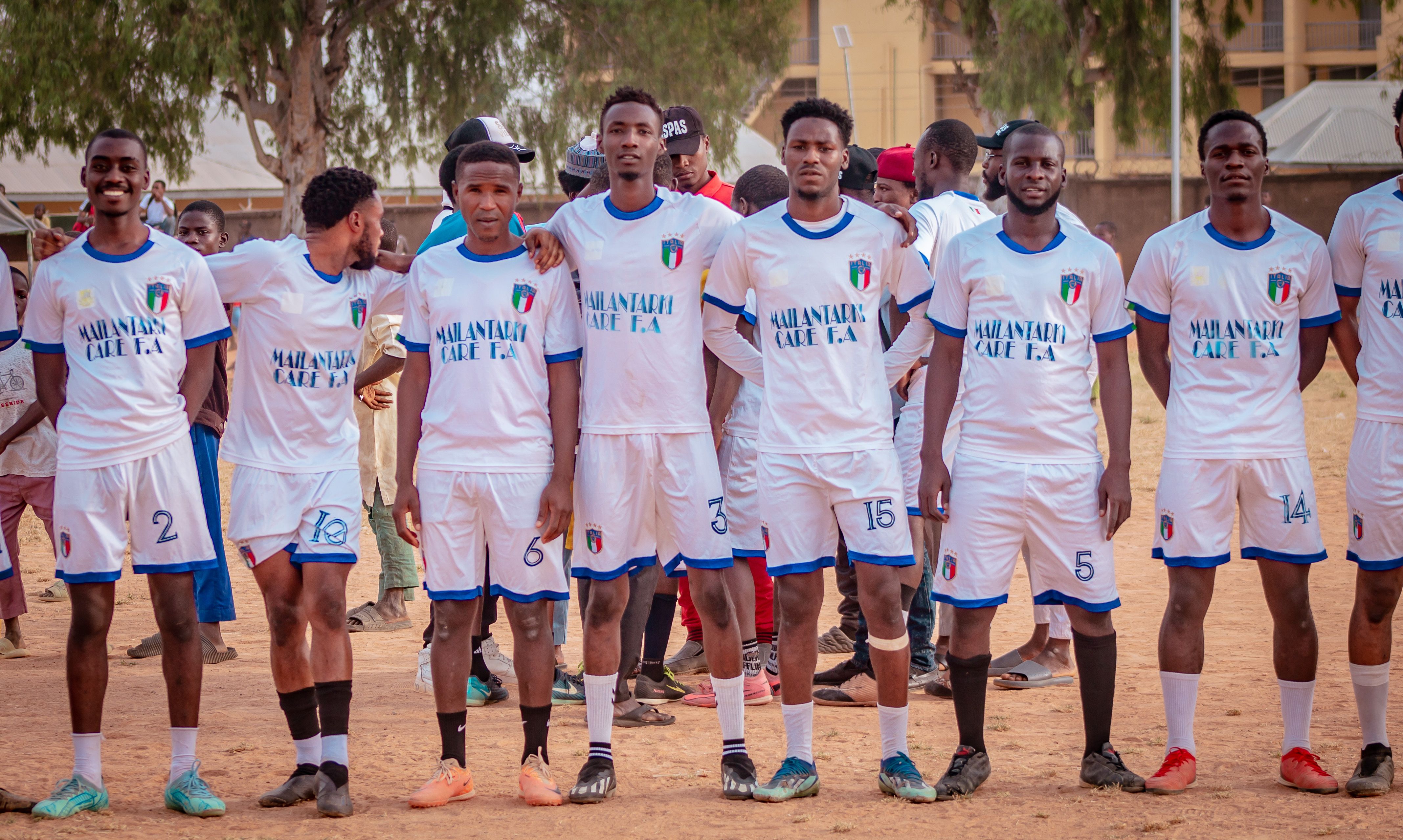 Team of Football Players Posing on Field · Free Stock Photo