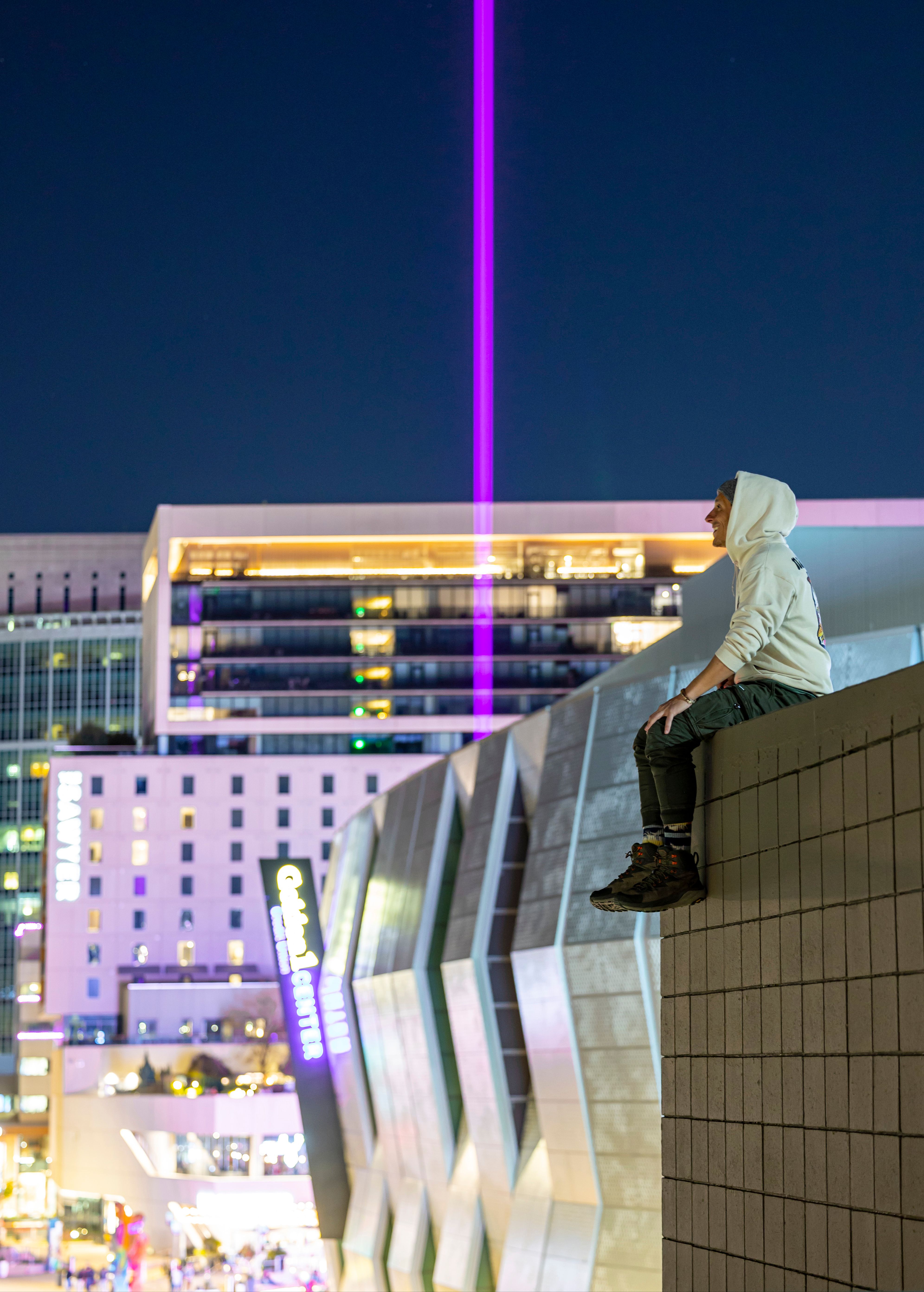 Person Sitting on Urban Edge at Night · Free Stock Photo