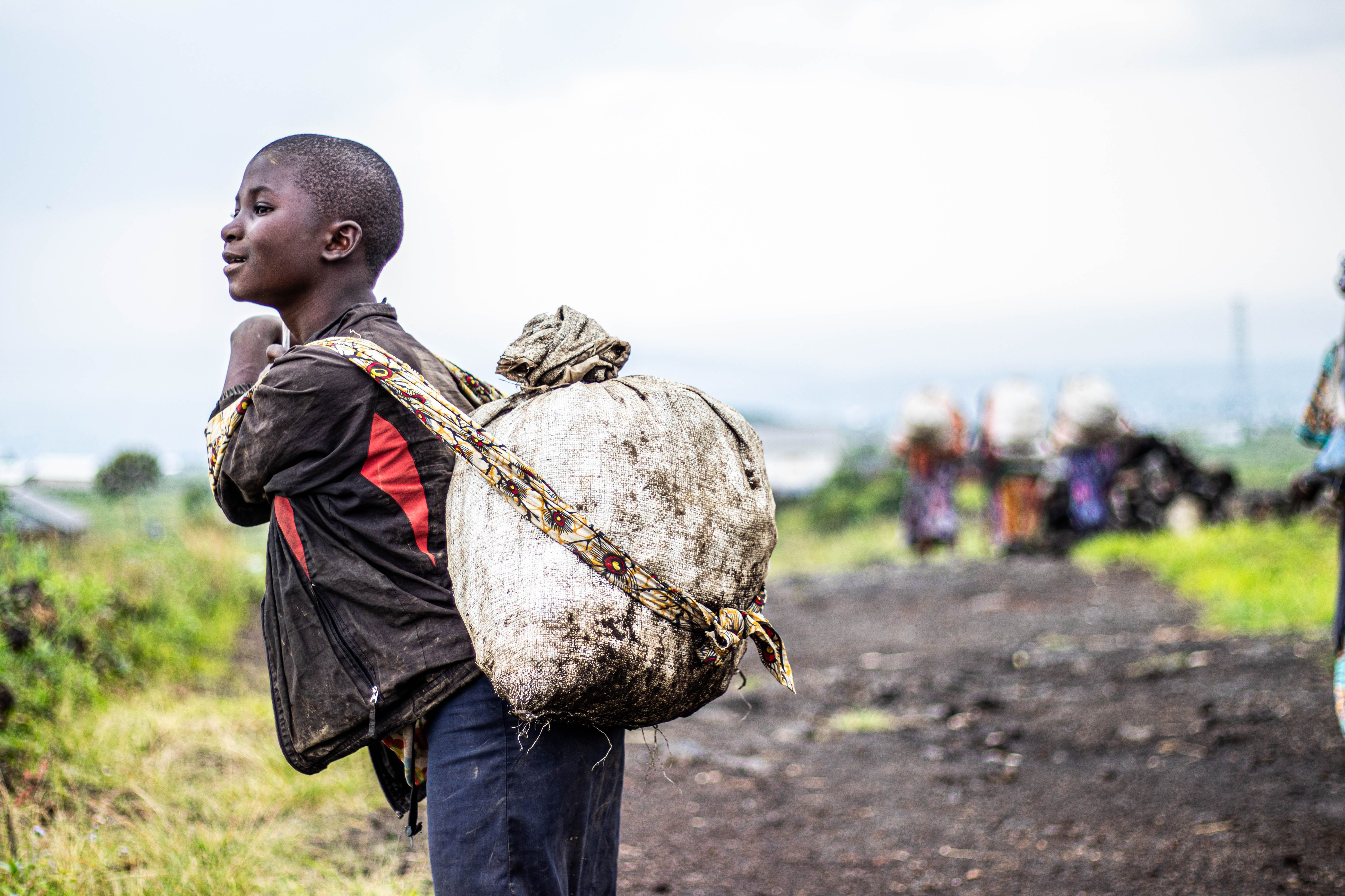 Young Boy Carrying Heavy Load Outdoors · Free Stock Photo