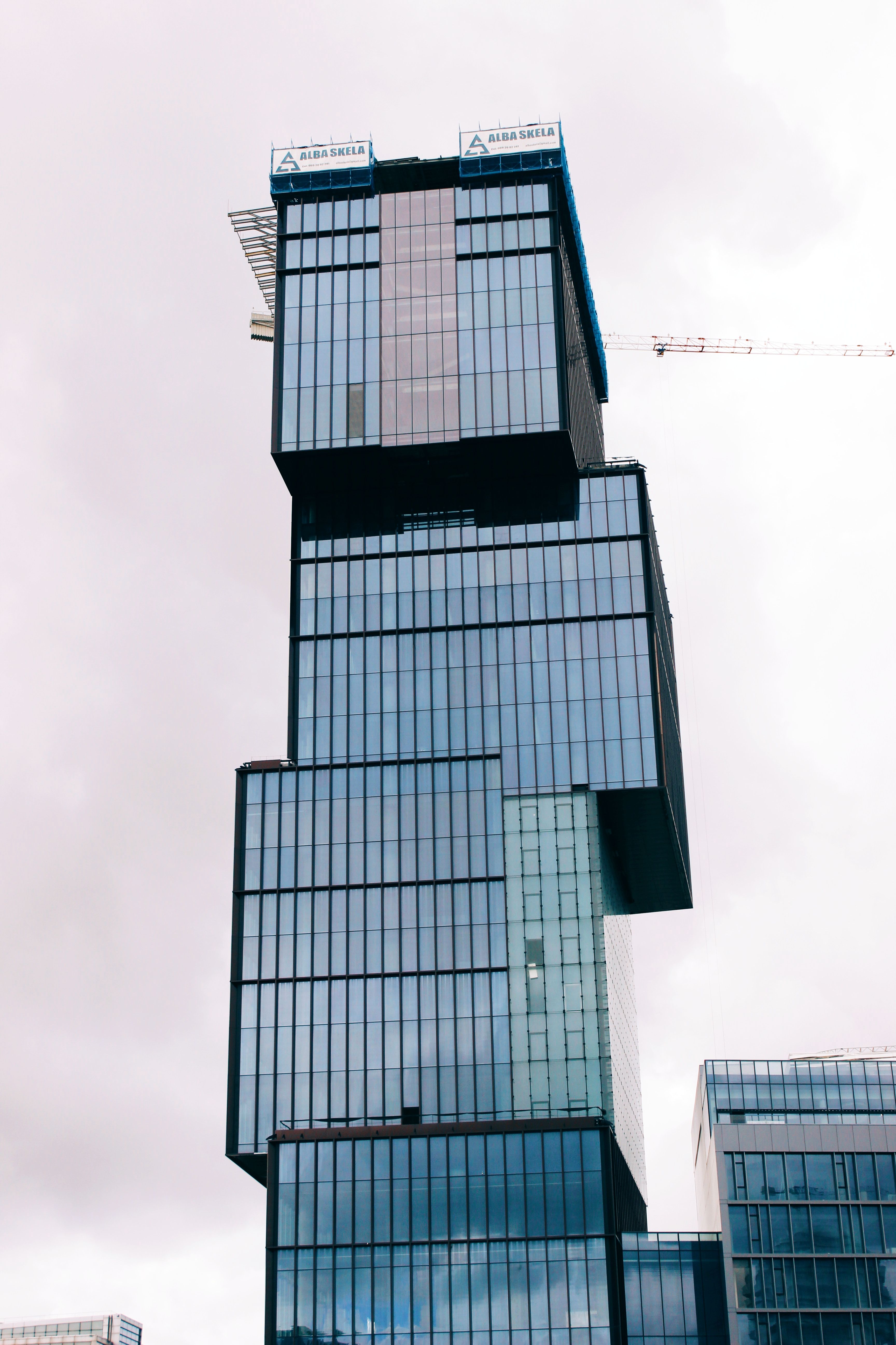 Modern Glass Skyscraper Against Overcast Sky · Free Stock Photo