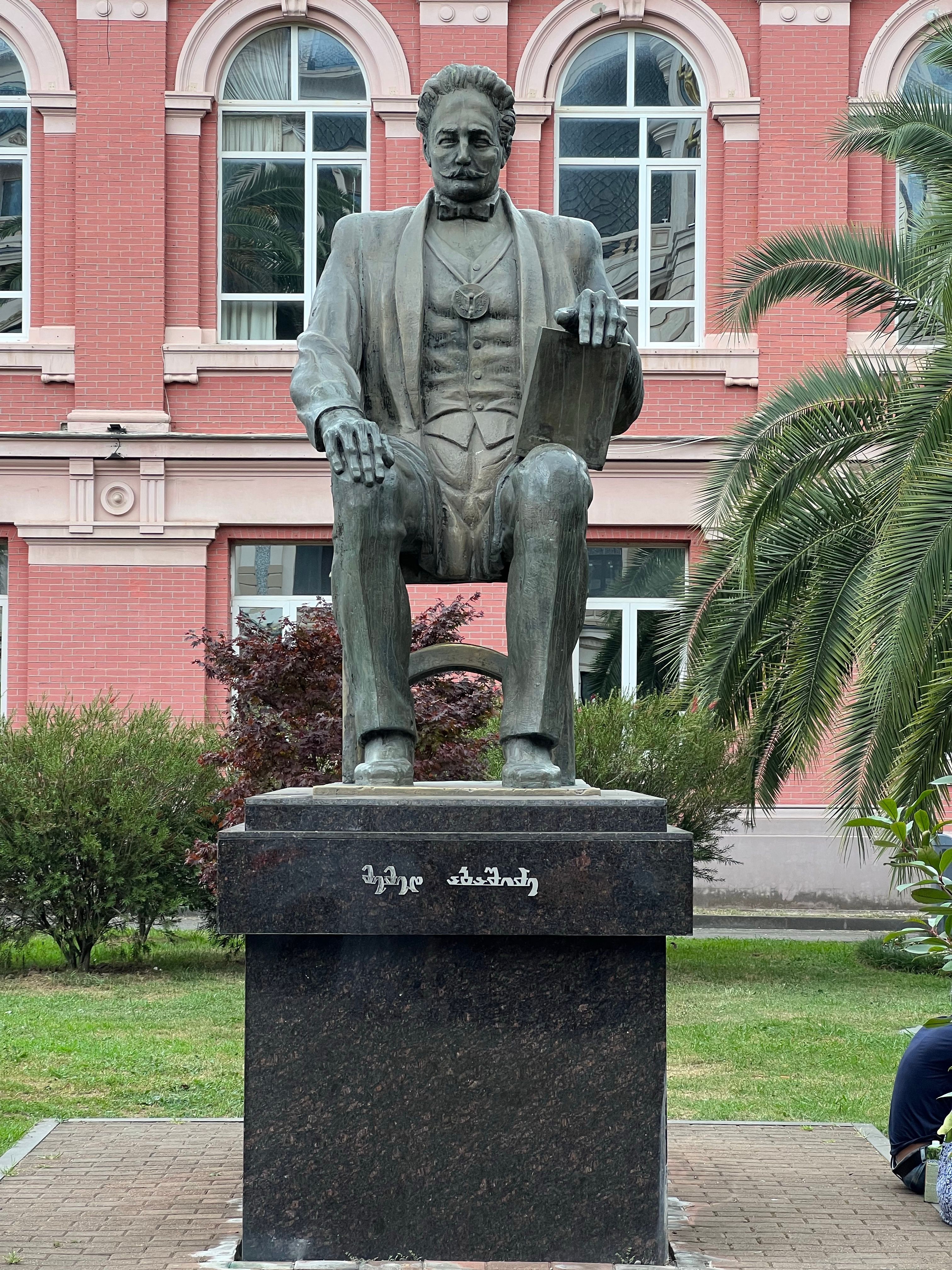 Statue of a Seated Man in Urban Park · Free Stock Photo
